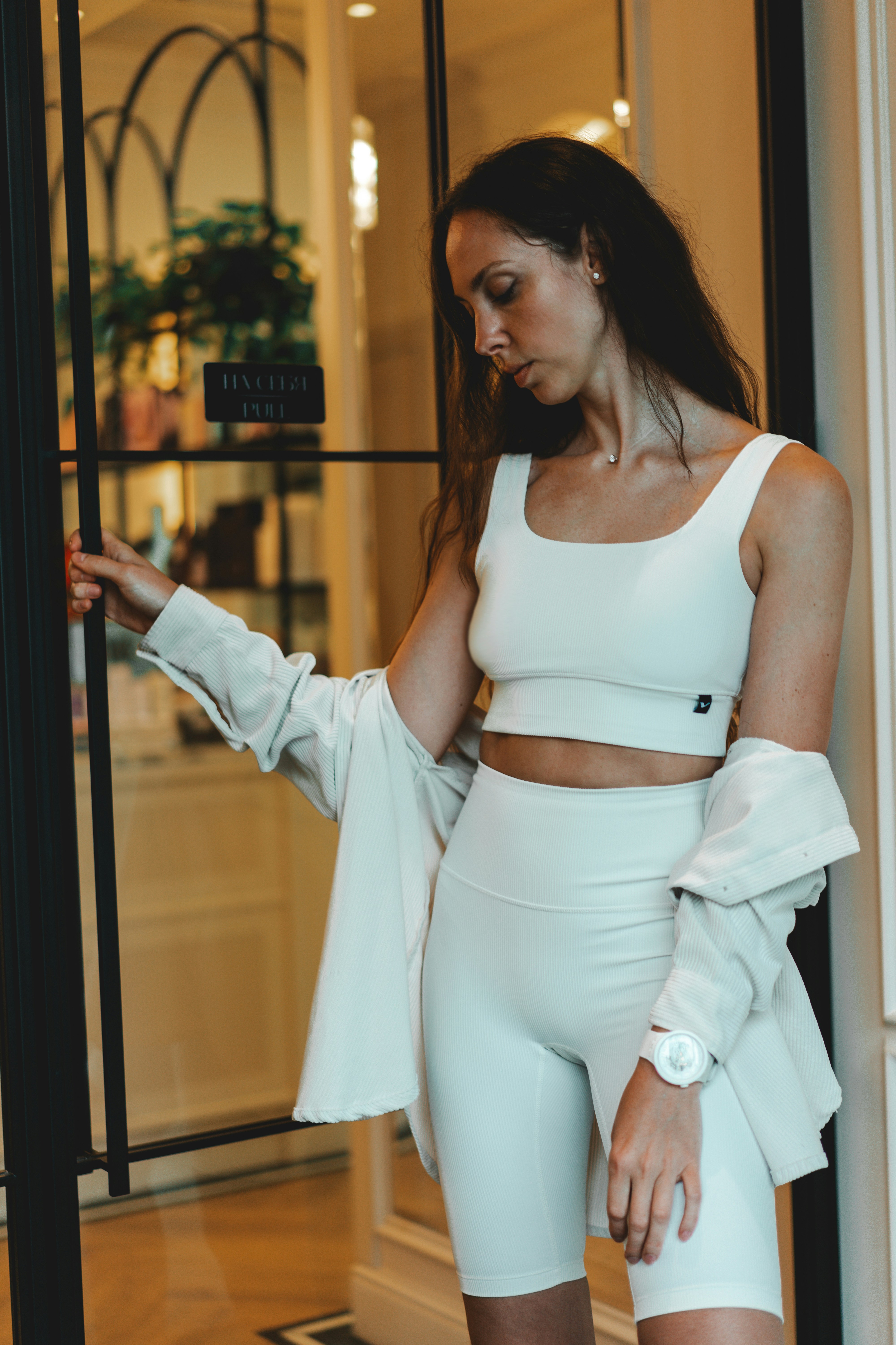 Woman in white workout clothes poses by a door. photo – Free Sport ...