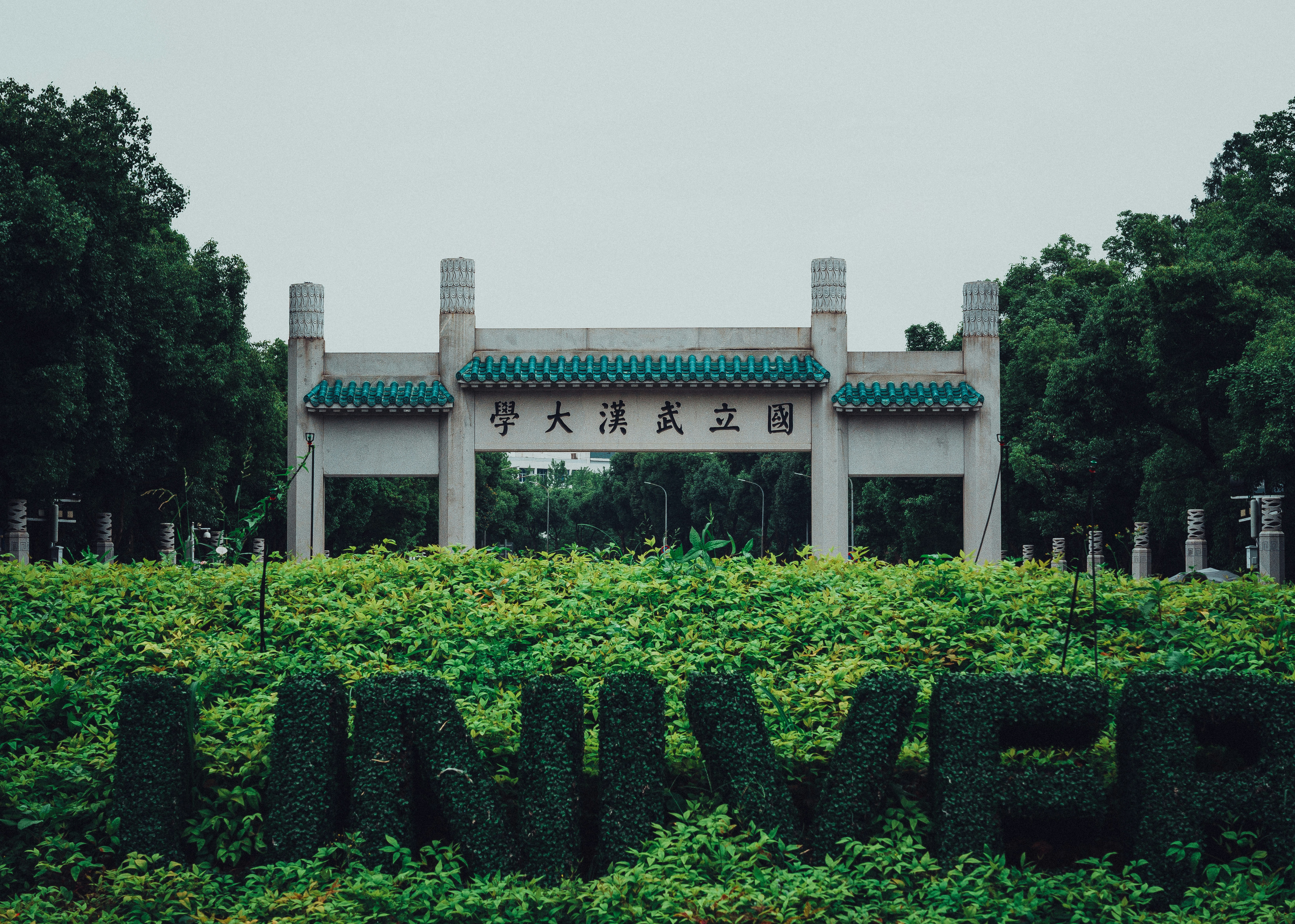 A university gate surrounded by greenery and foliage. photo – Free ...