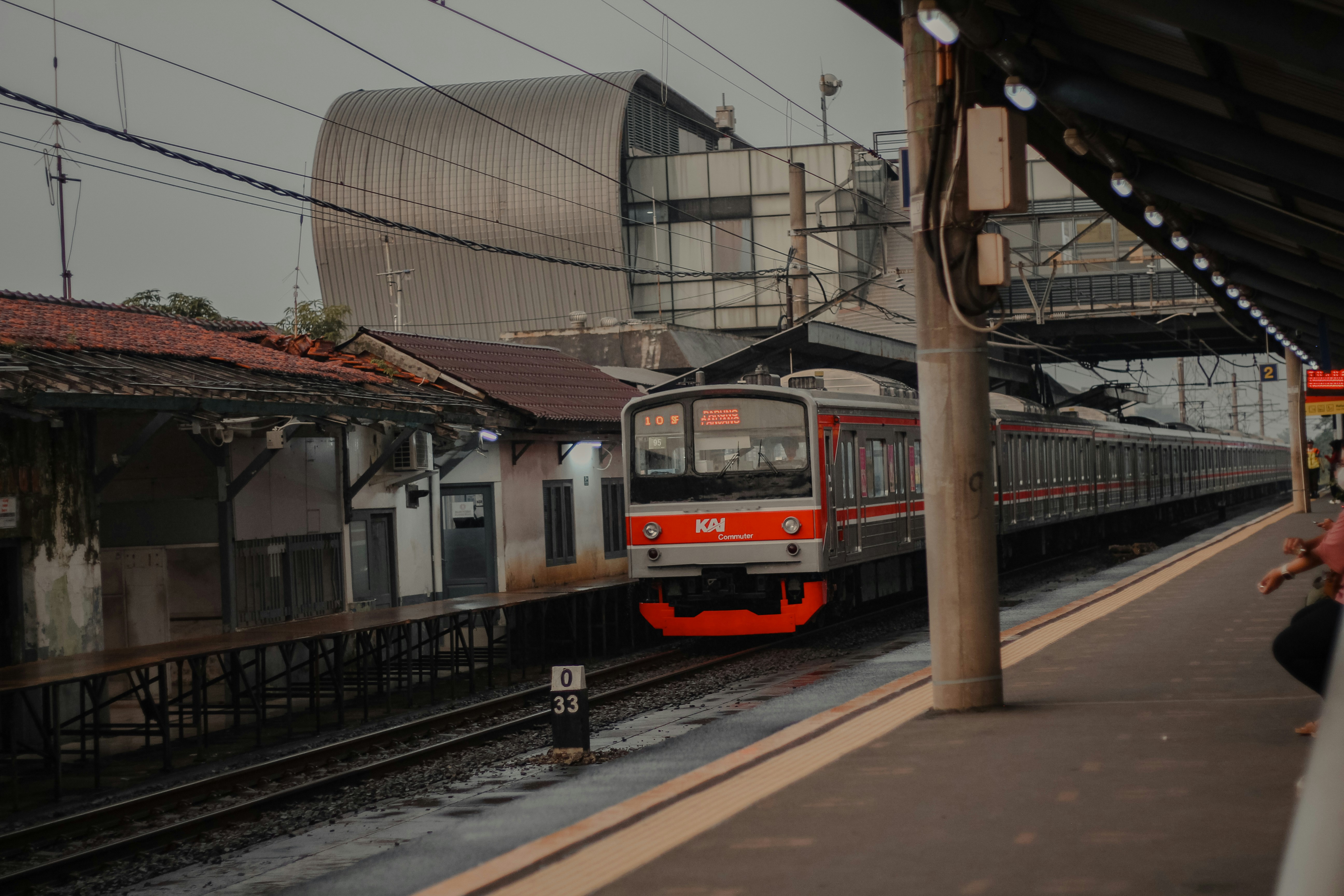 Train coming at the station | A train pulls into a station on a cloudy day.