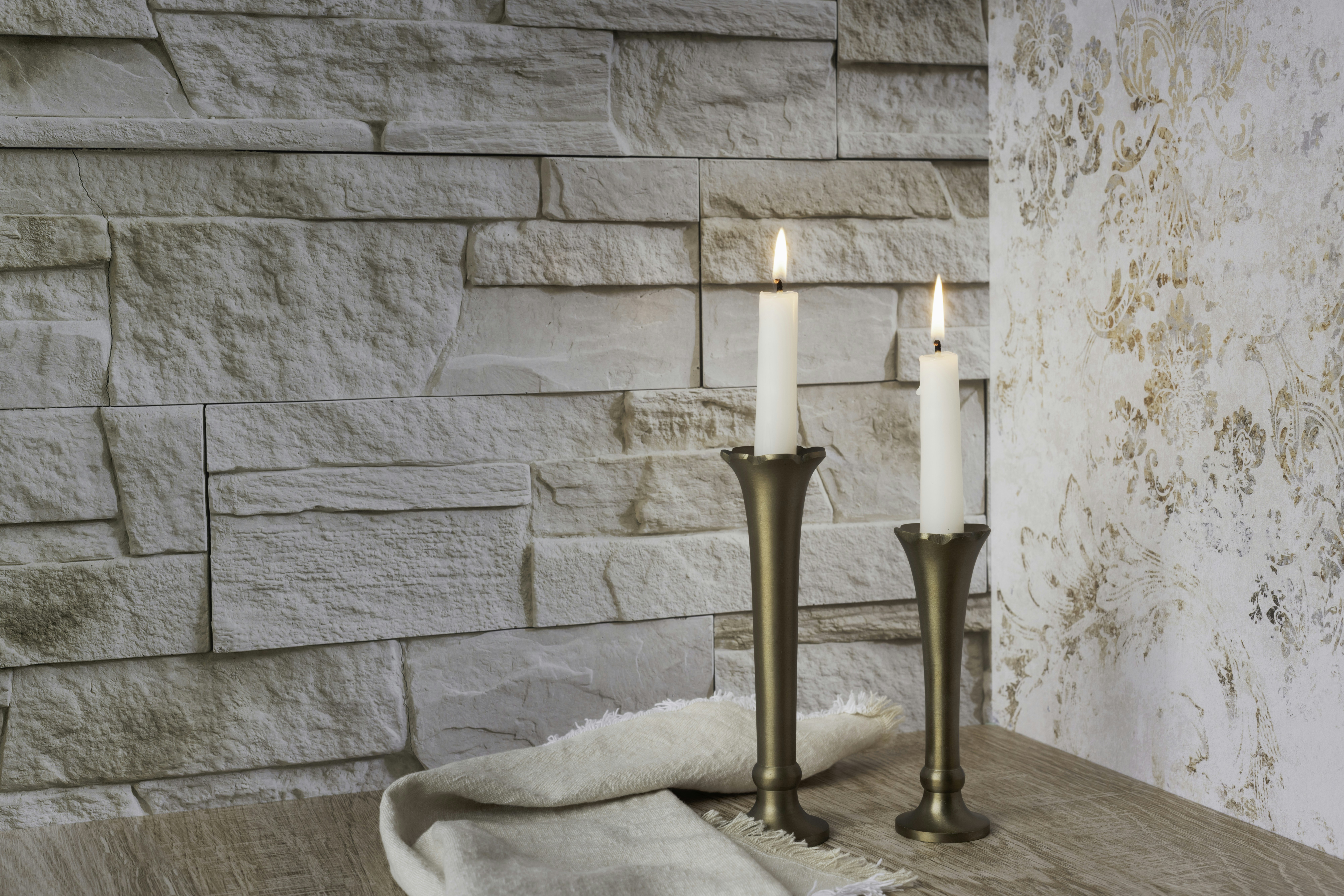 Candlelight Duet on a Linen Table: Brass Candlesticks by a Stone Wall