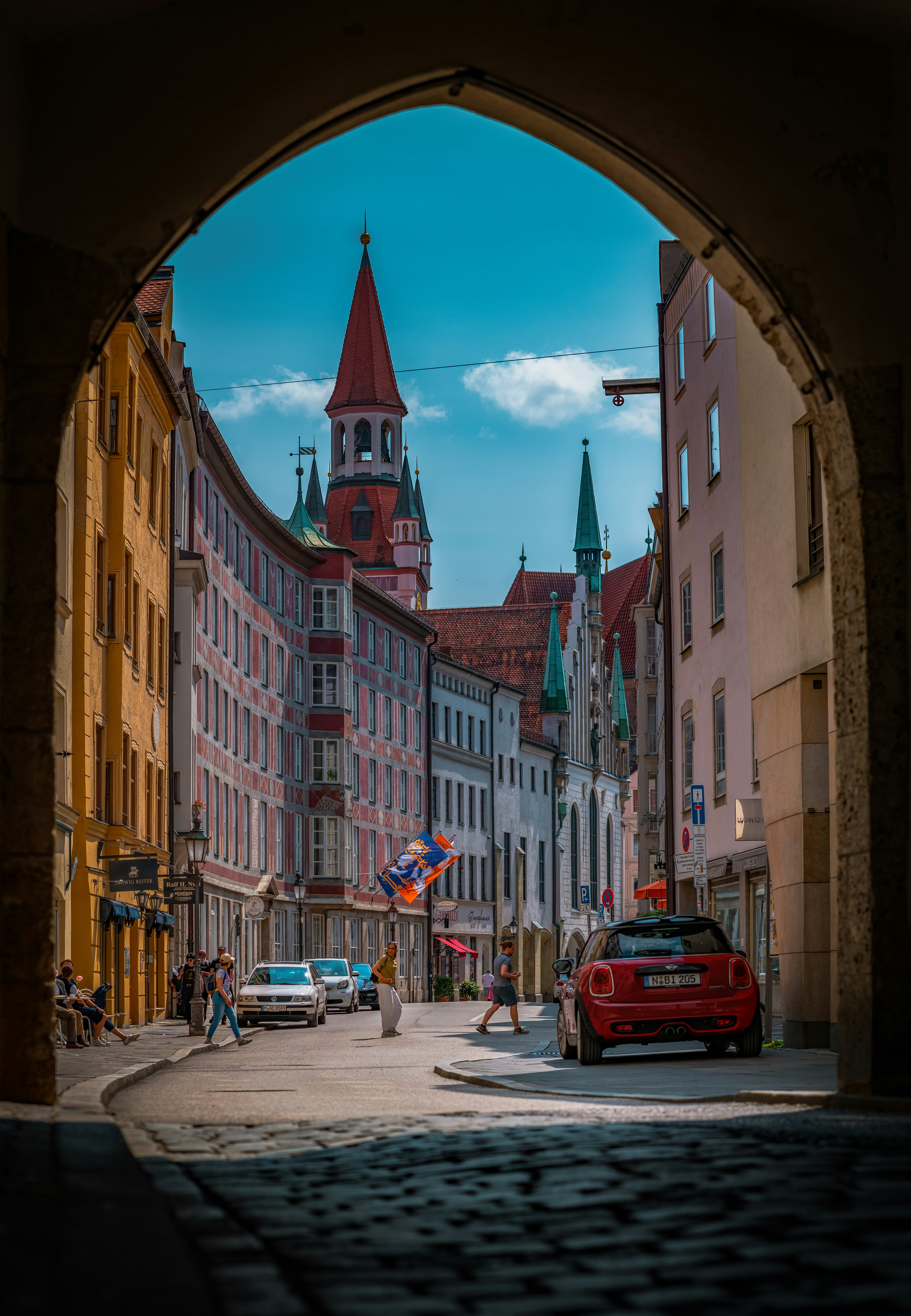Through the Arch: a Sunlit Street of Pastel Facades and Towering Spires