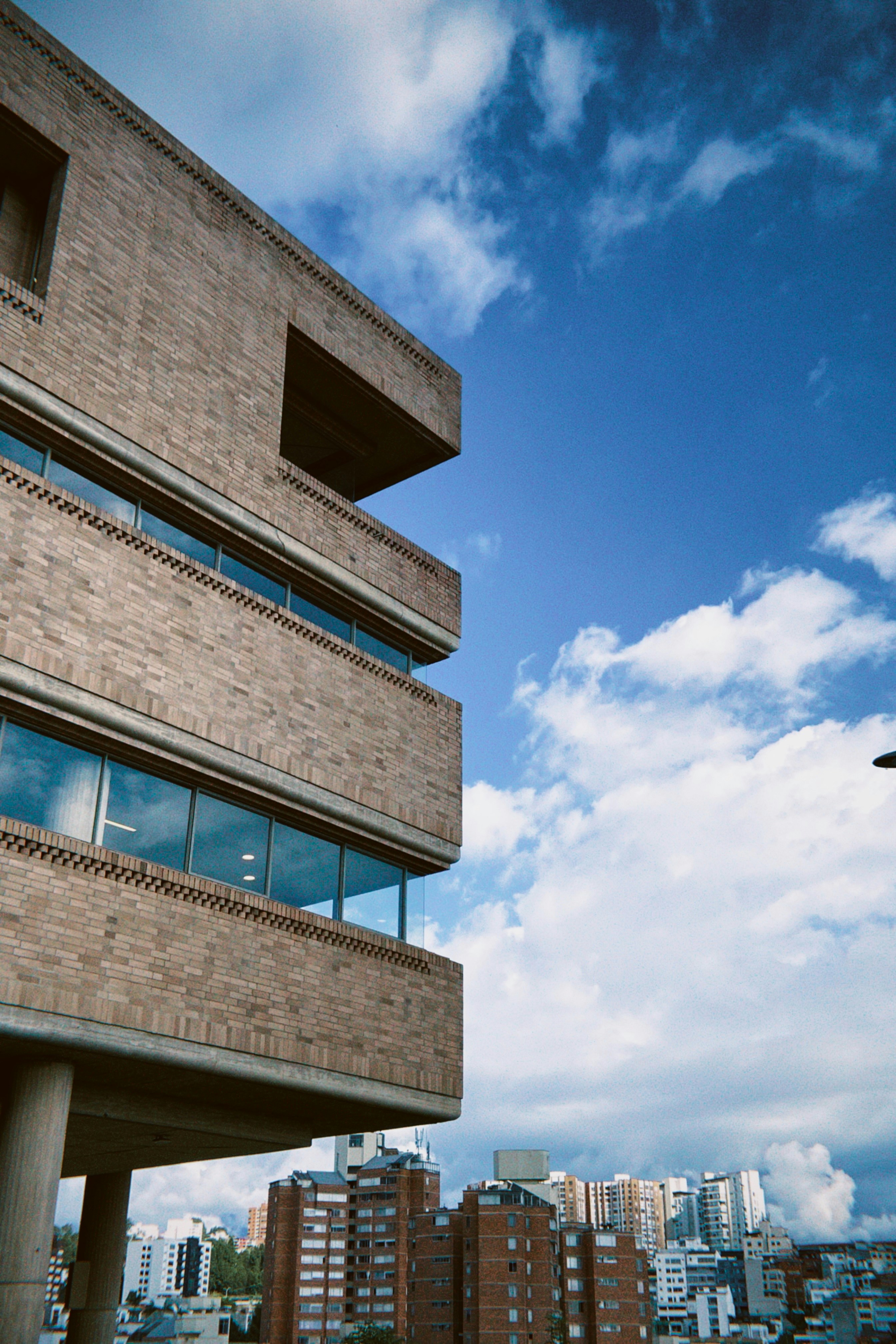 Mirada a la ciudad desde la biblioteca | Brick building against a bright blue sky.