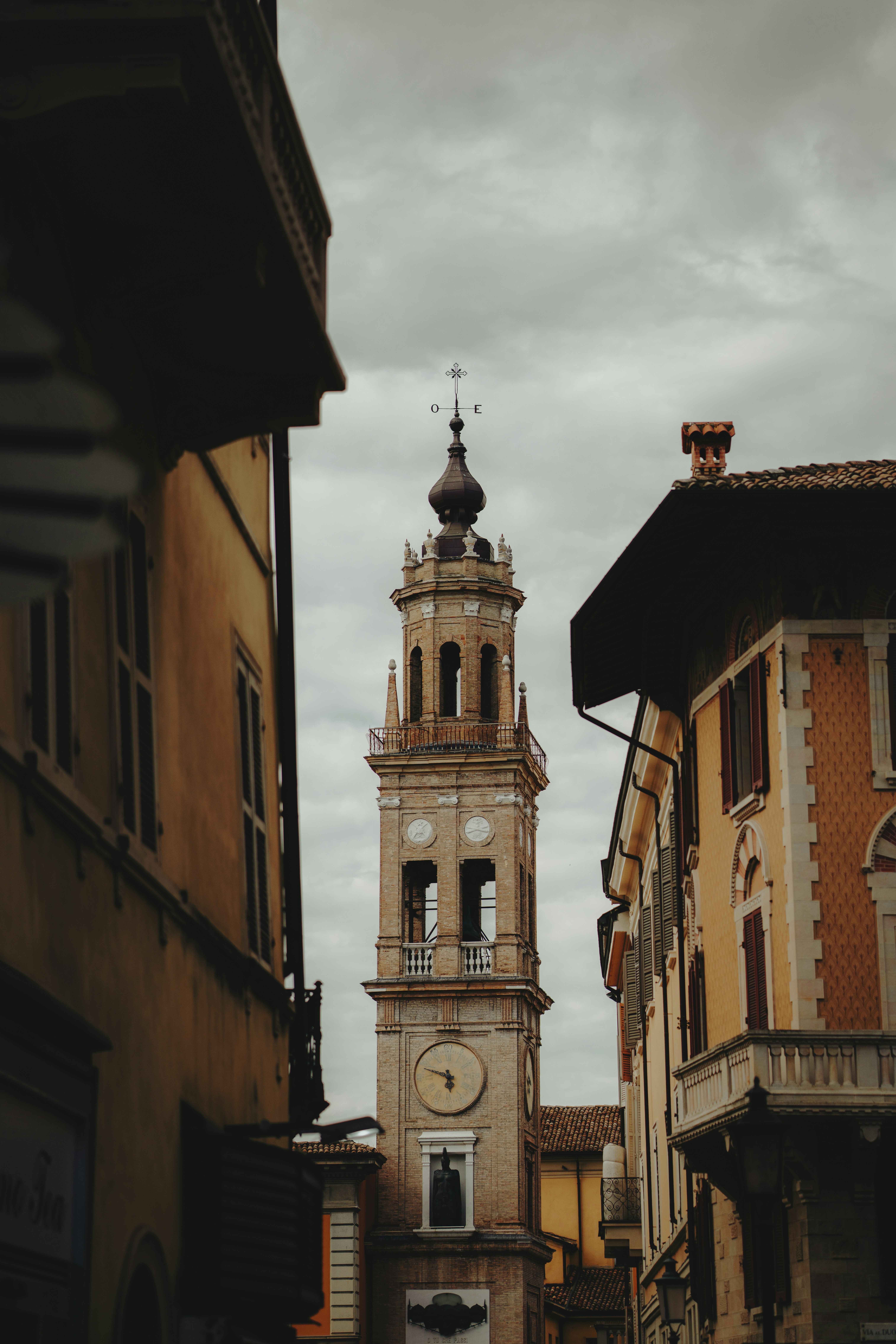 A tall clock tower rises between buildings.