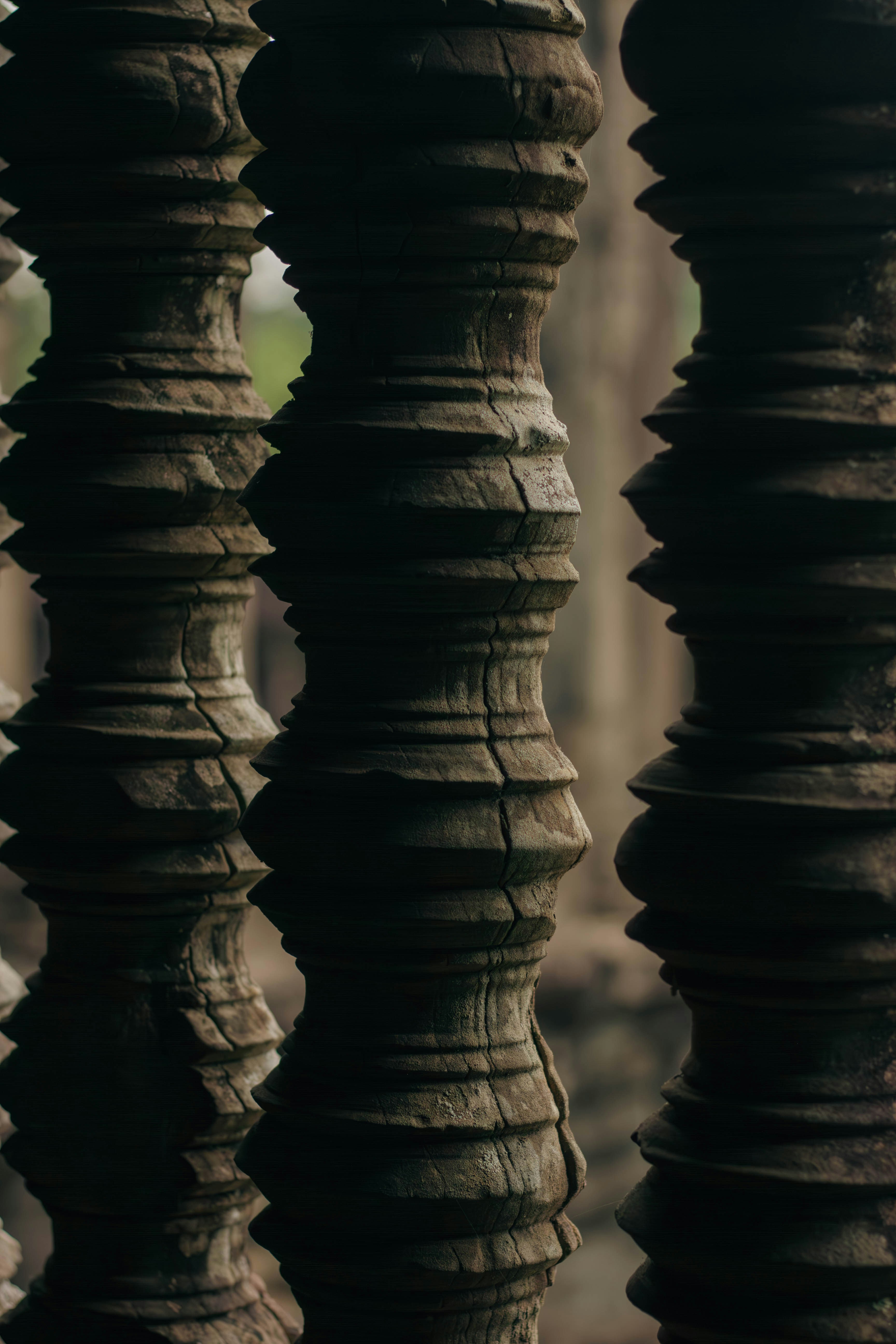 Ribbed Silence: Ancient Carved Columns in Dim Light