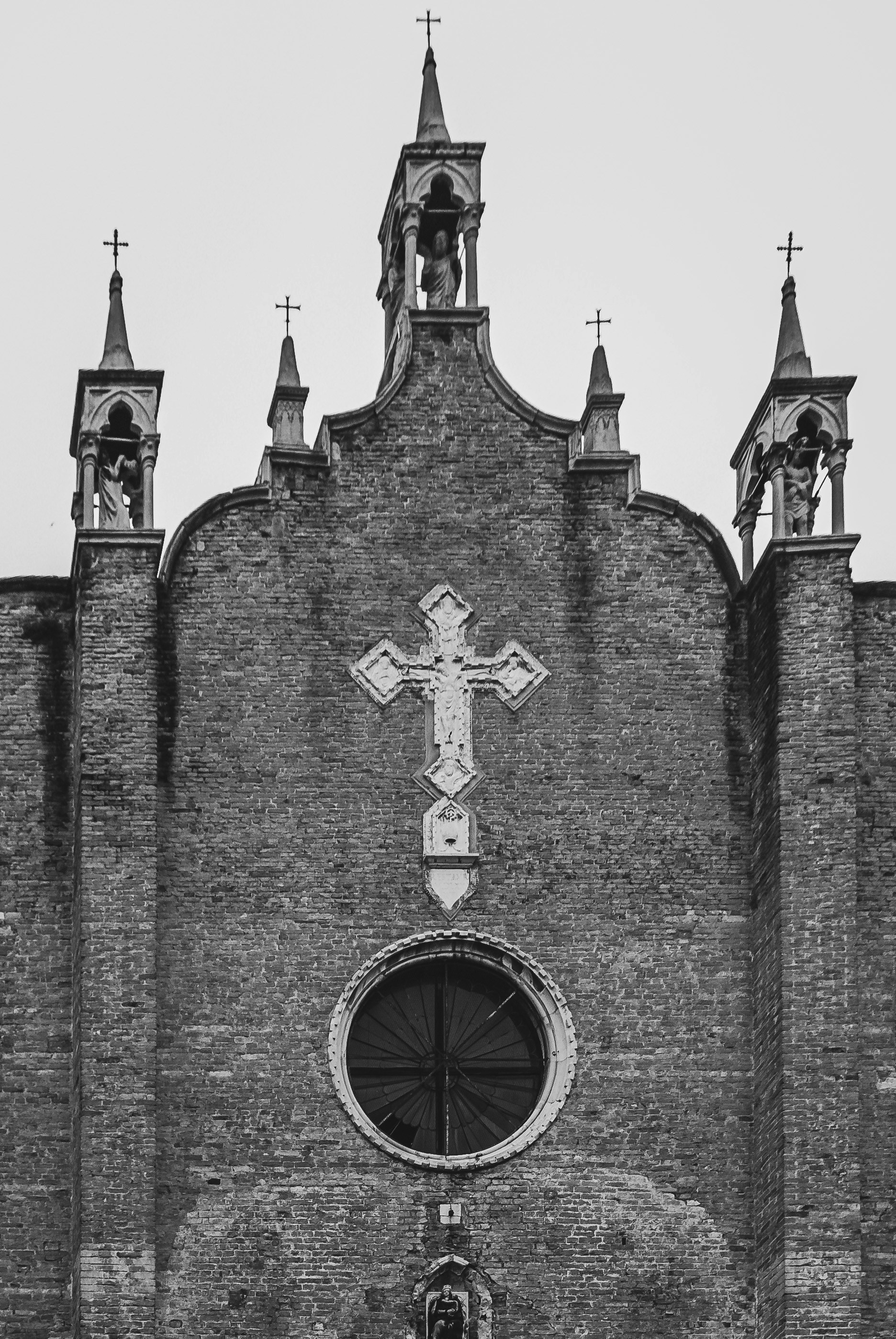 Church facade with a large cross and towers.