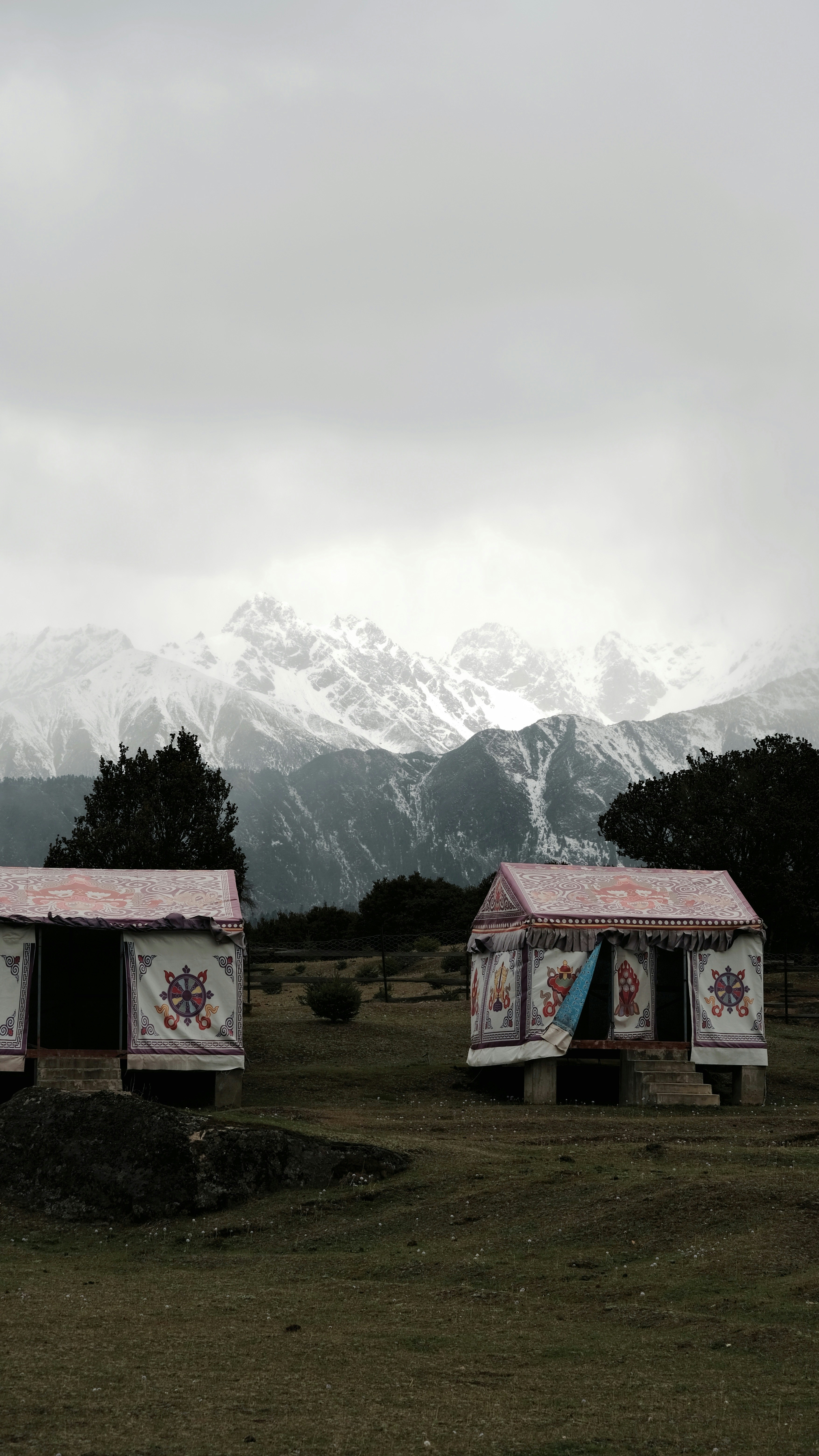 Colorful Tents Stand Watch Before a Snow-Capped Range