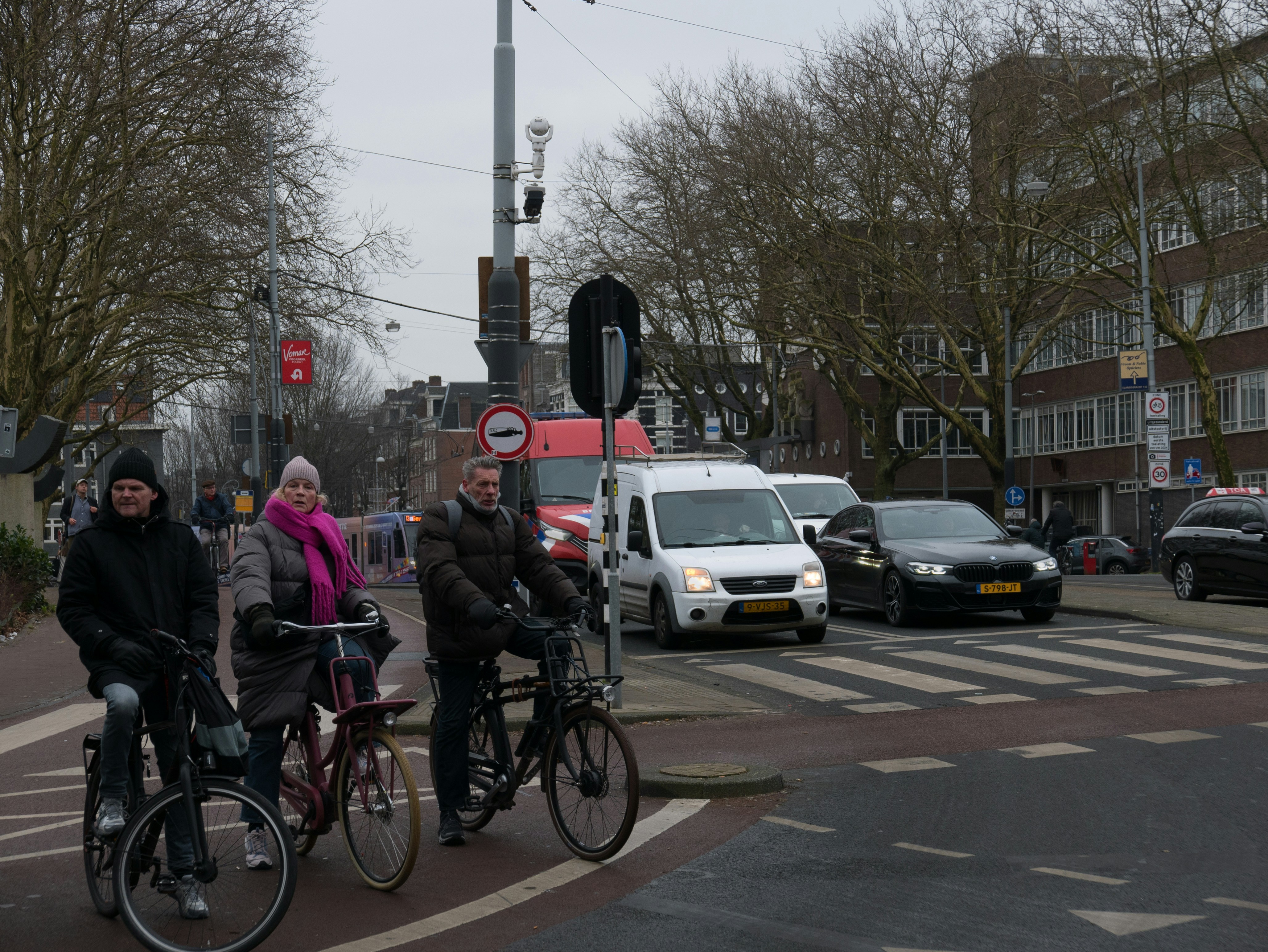 Crosswalk Pause: Three Cyclists Await the Signal