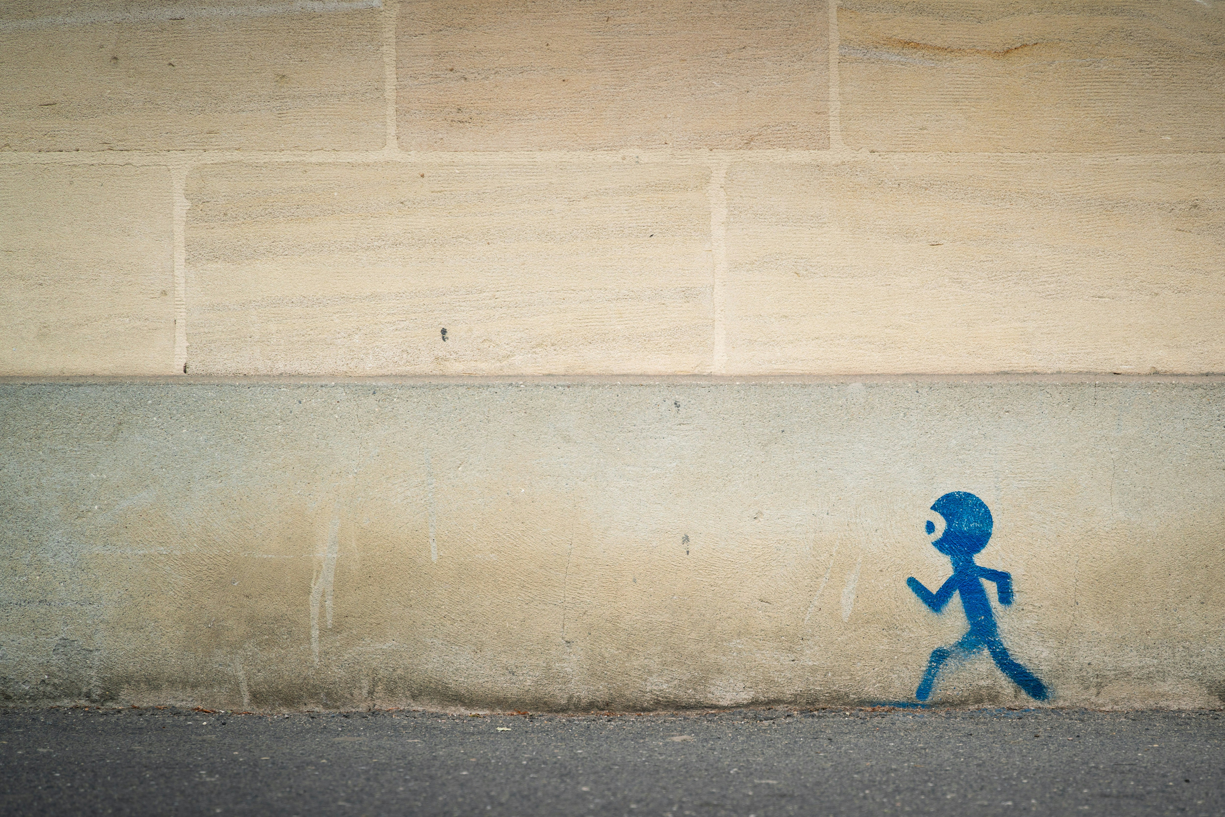 A blue stick figure runs against the wall. photo – Free Image on Unsplash