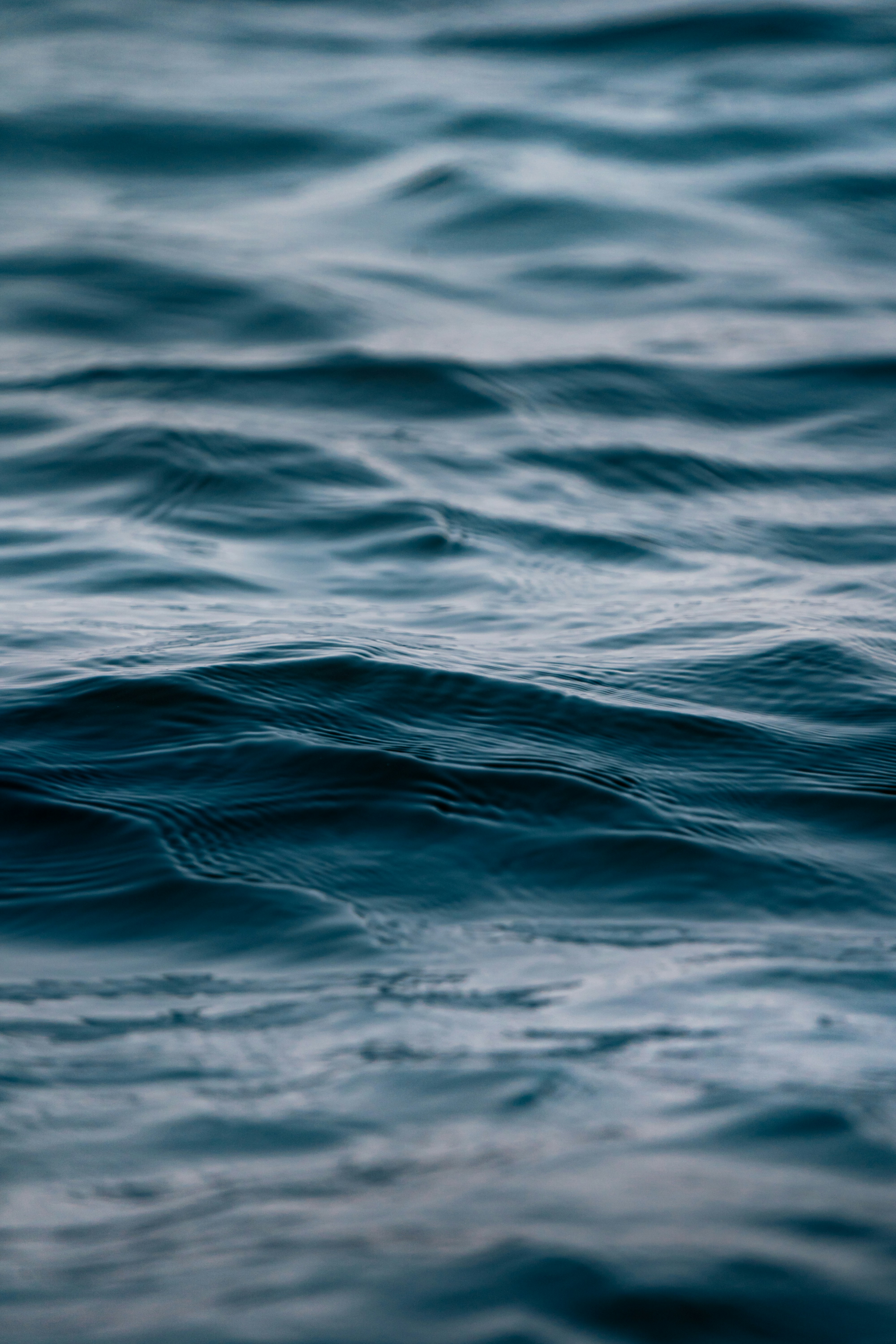 Gentle ripples on a tranquil body of water, reflecting subtle shades of blue and gray.