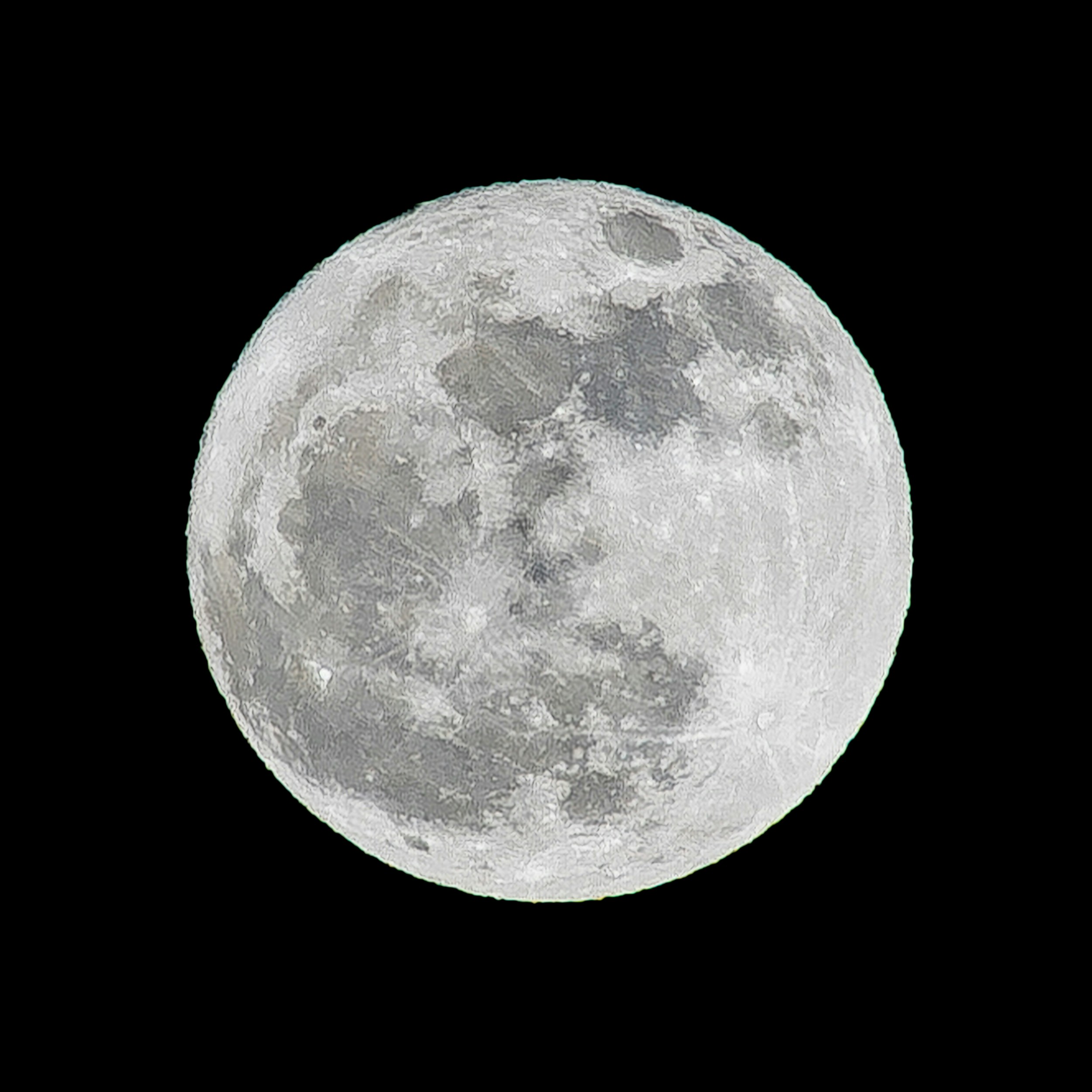Full moon illuminating the night sky, showcasing intricate surface details and craters against a stark black backdrop.