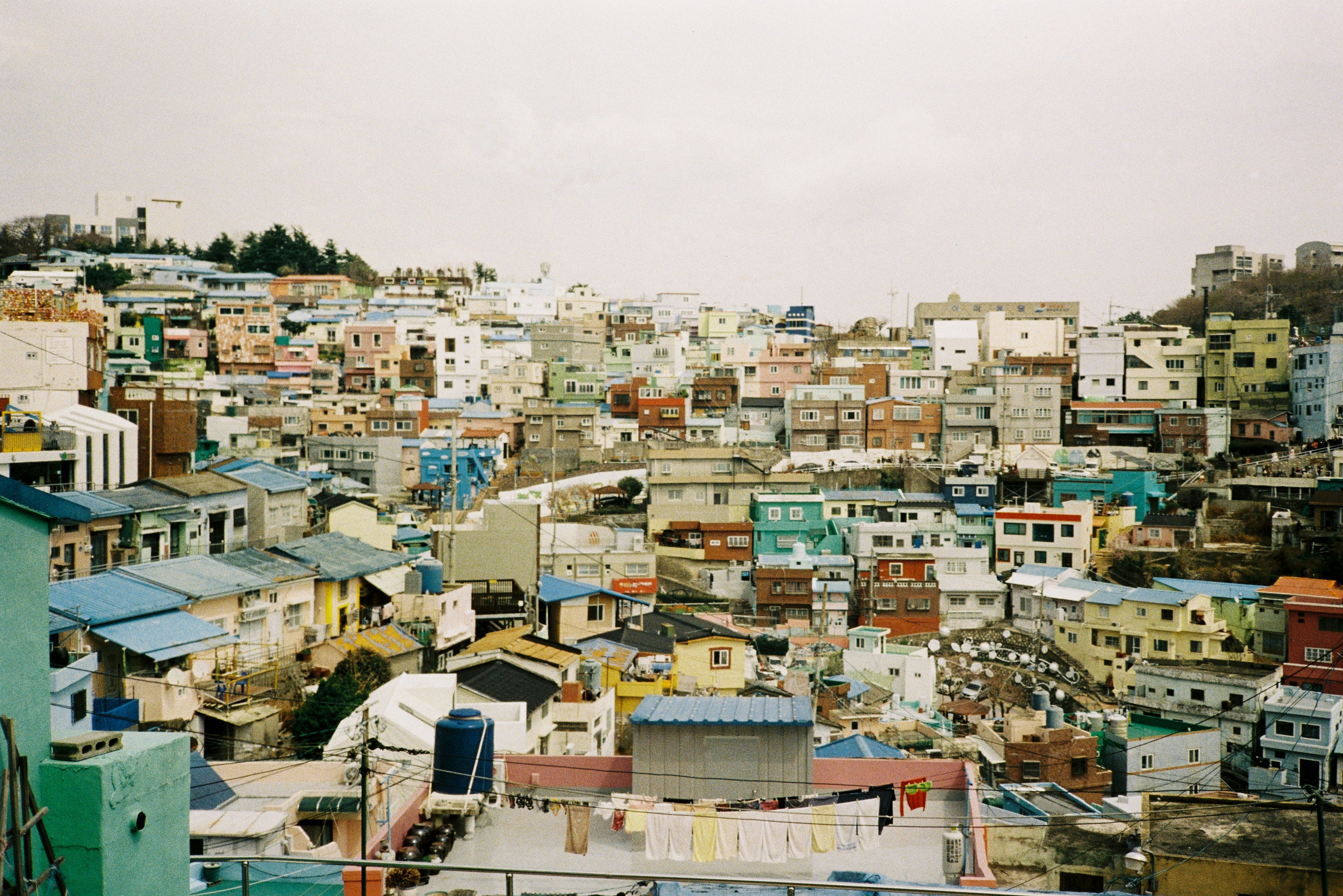 A colorful hillside town under a cloudy sky.