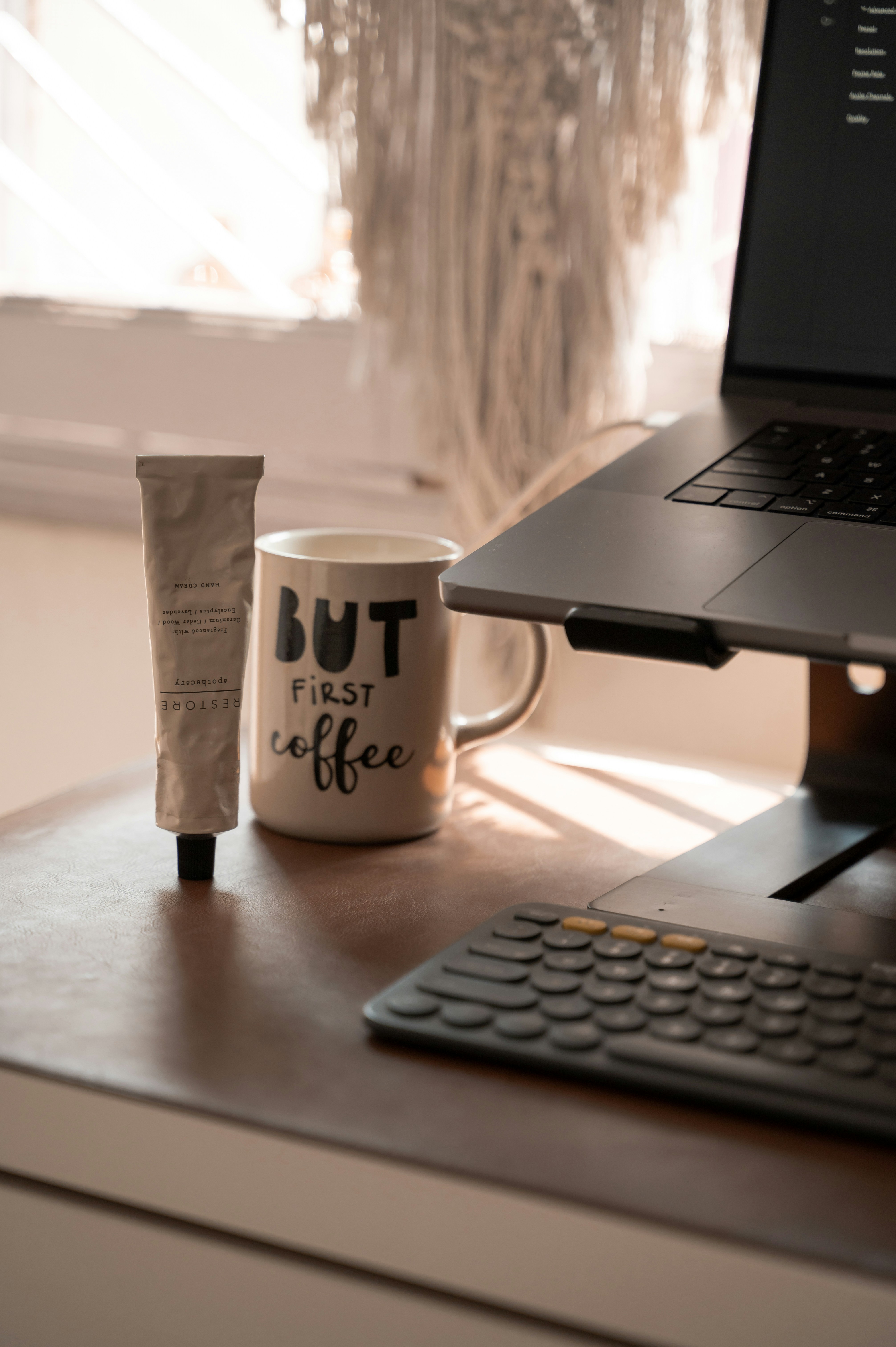 Caffeinated Workflow: A Laptop, Mug, and Tube of Cream on a Cozy Desk