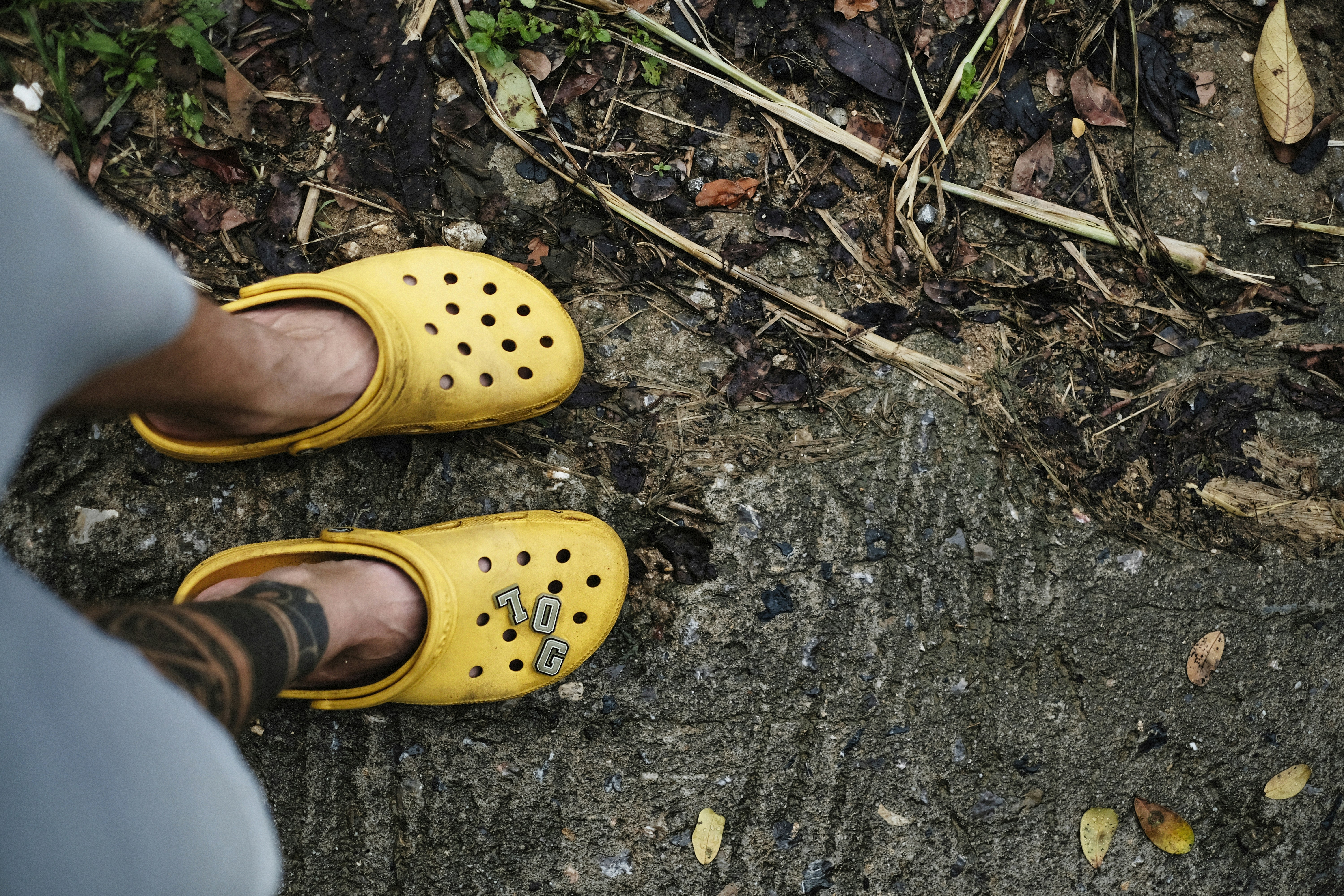 Ground-Level Portrait: Yellow Crocs Anchoring a Quiet Walk