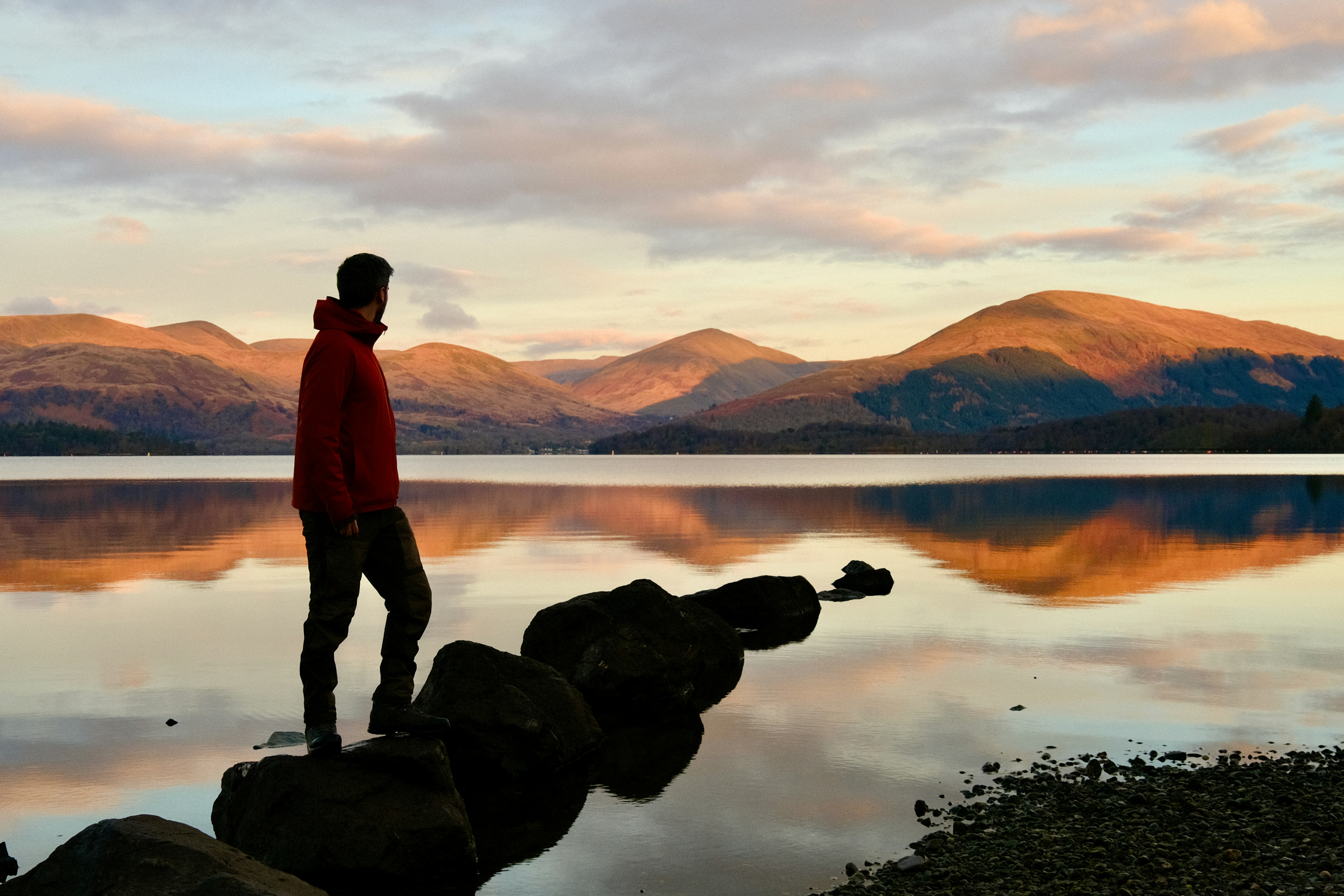 Red-Jacket Silhouette on a Glassy Lake at Sunset