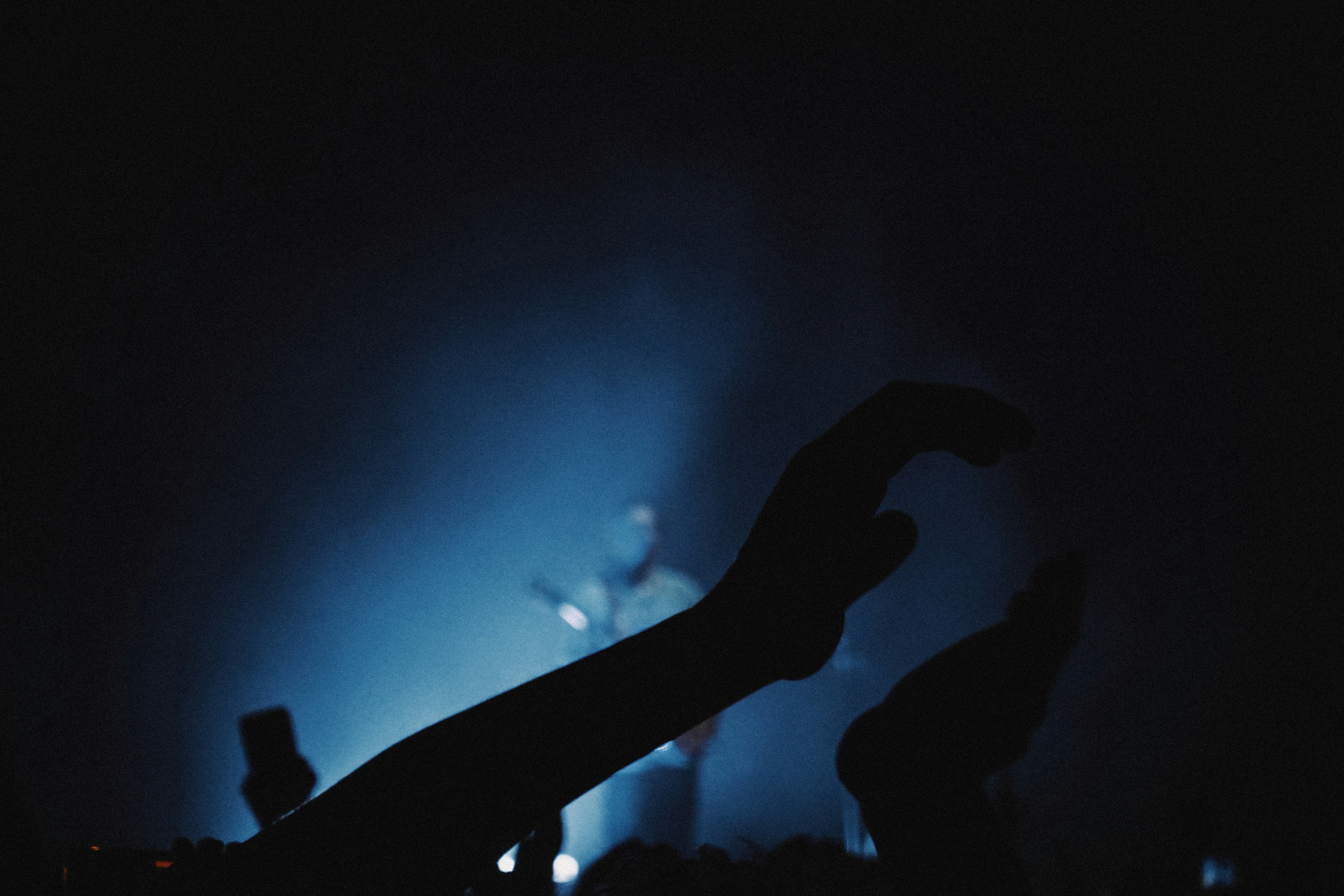 Hands reach towards a musician onstage.