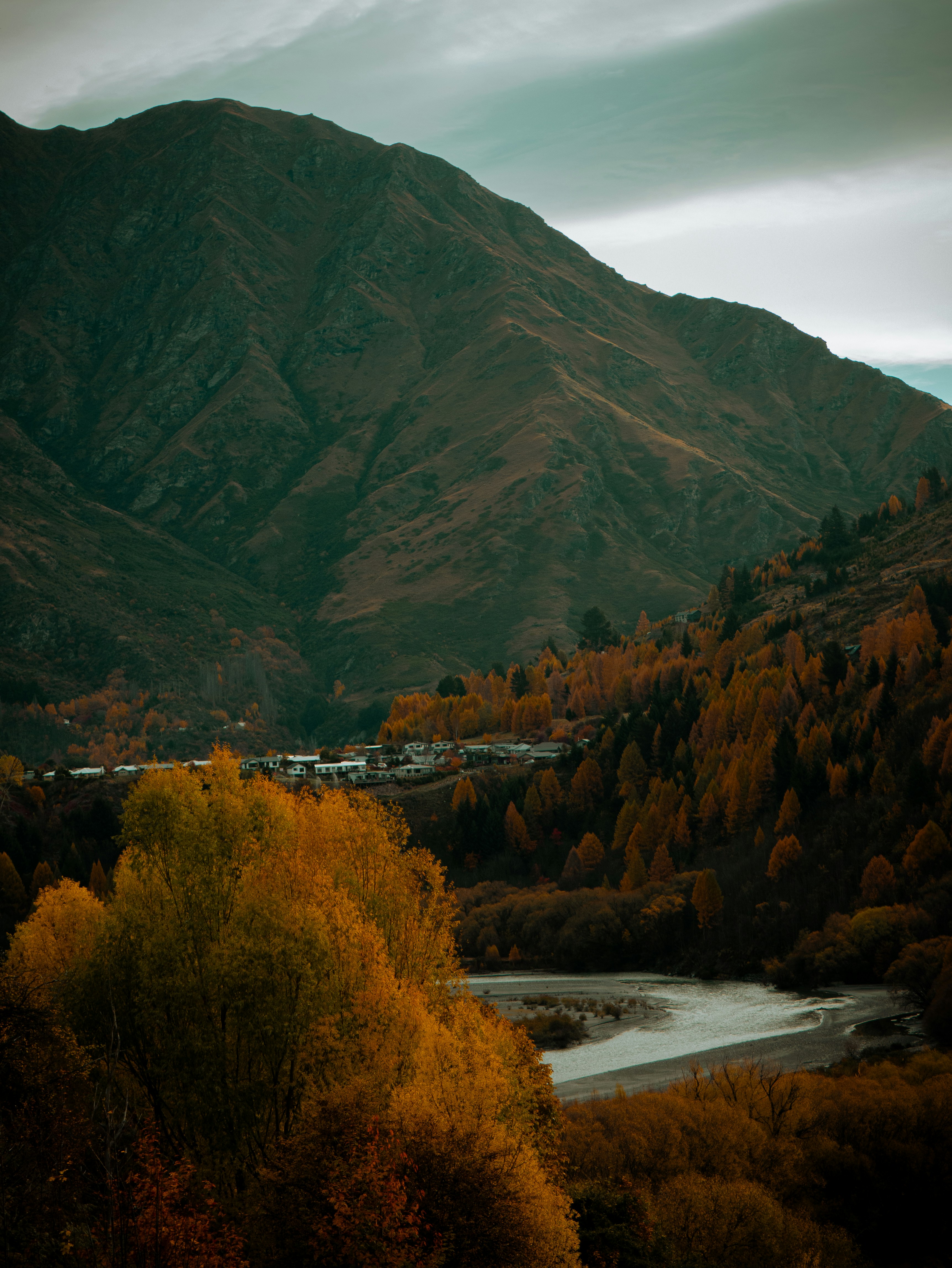 Mountains tower over an autumn-colored landscape.