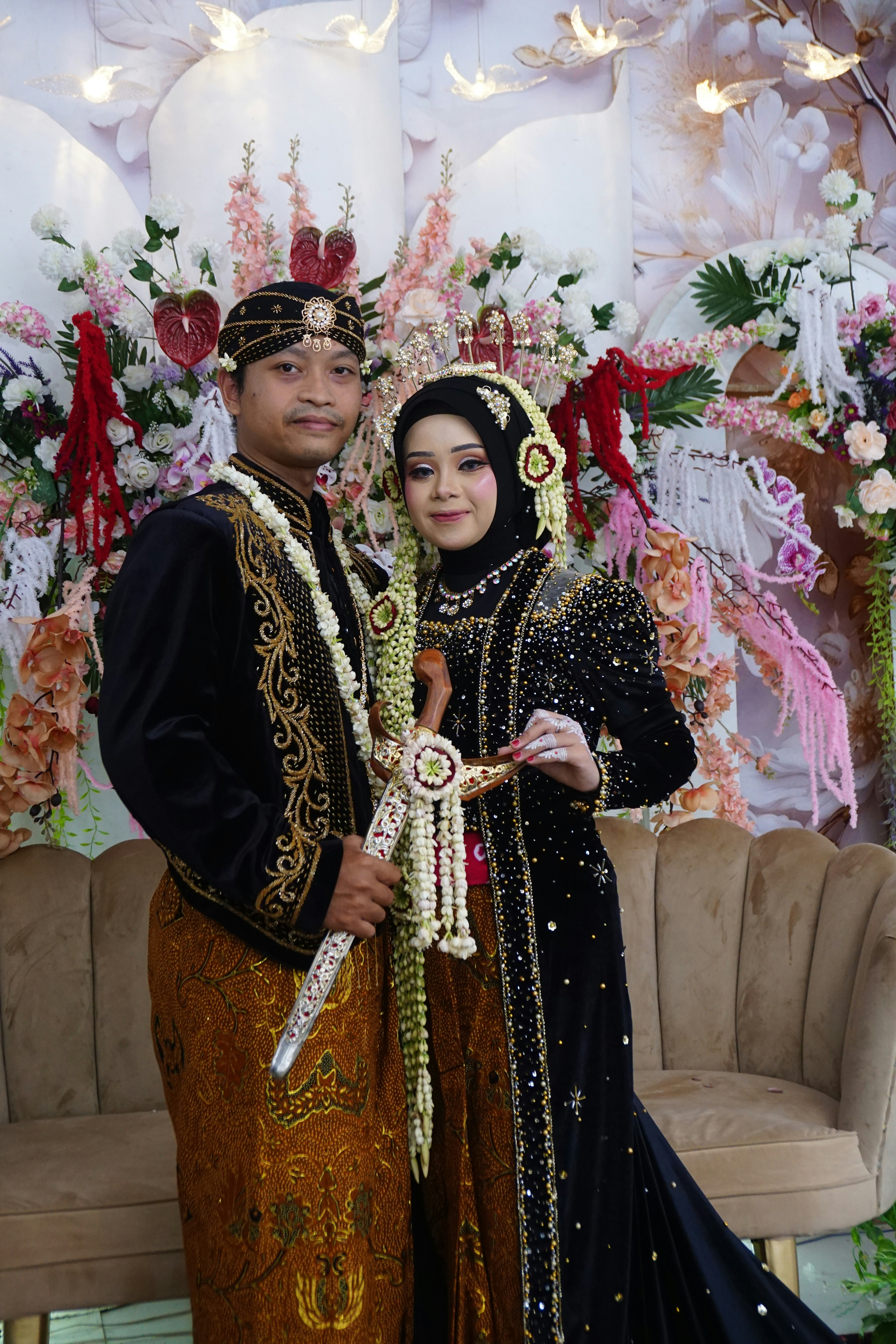 A newlywed couple poses in traditional indonesian wedding attire. photo ...