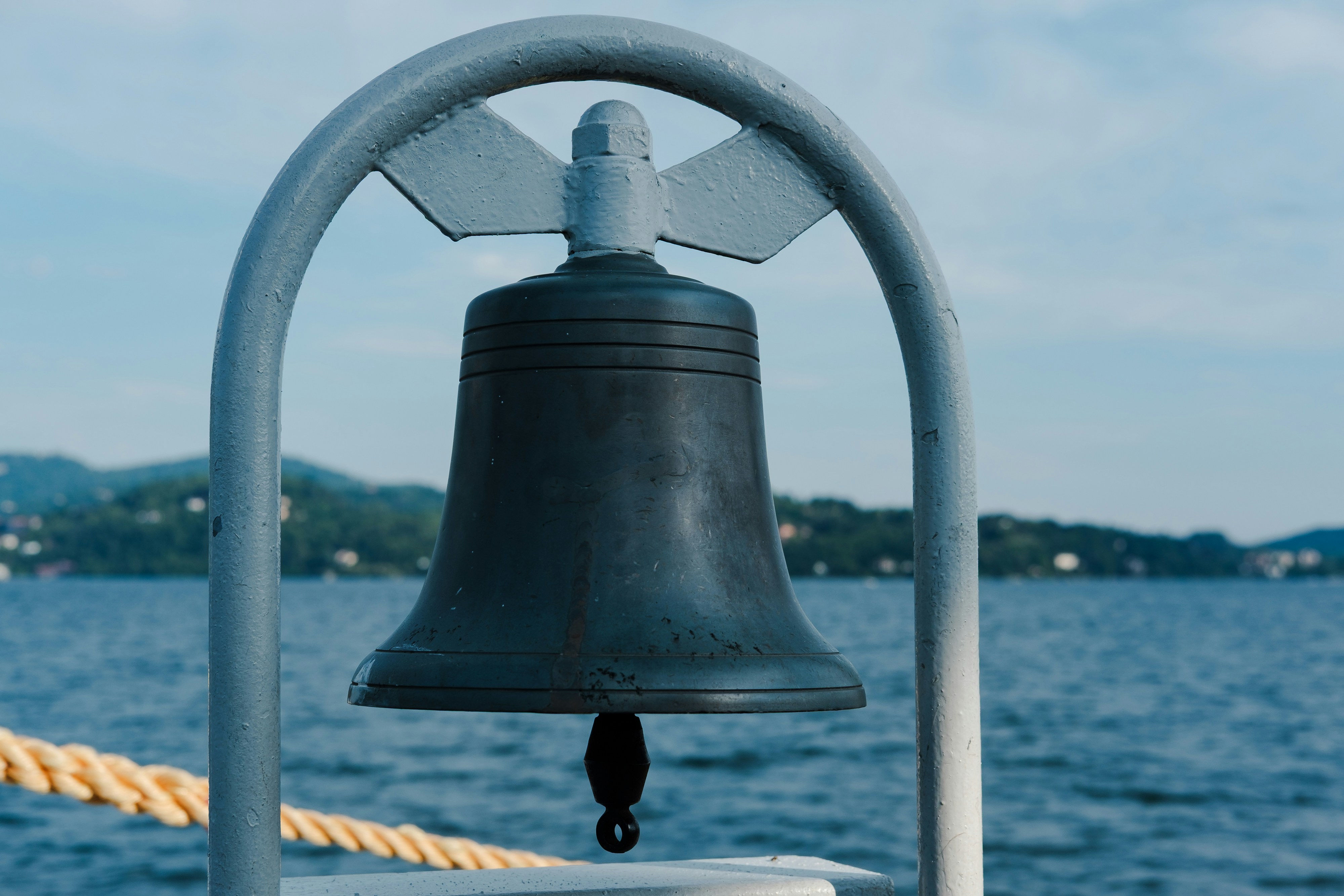 A bell hangs on a boat near the water. photo – Free Bell Image on Unsplash