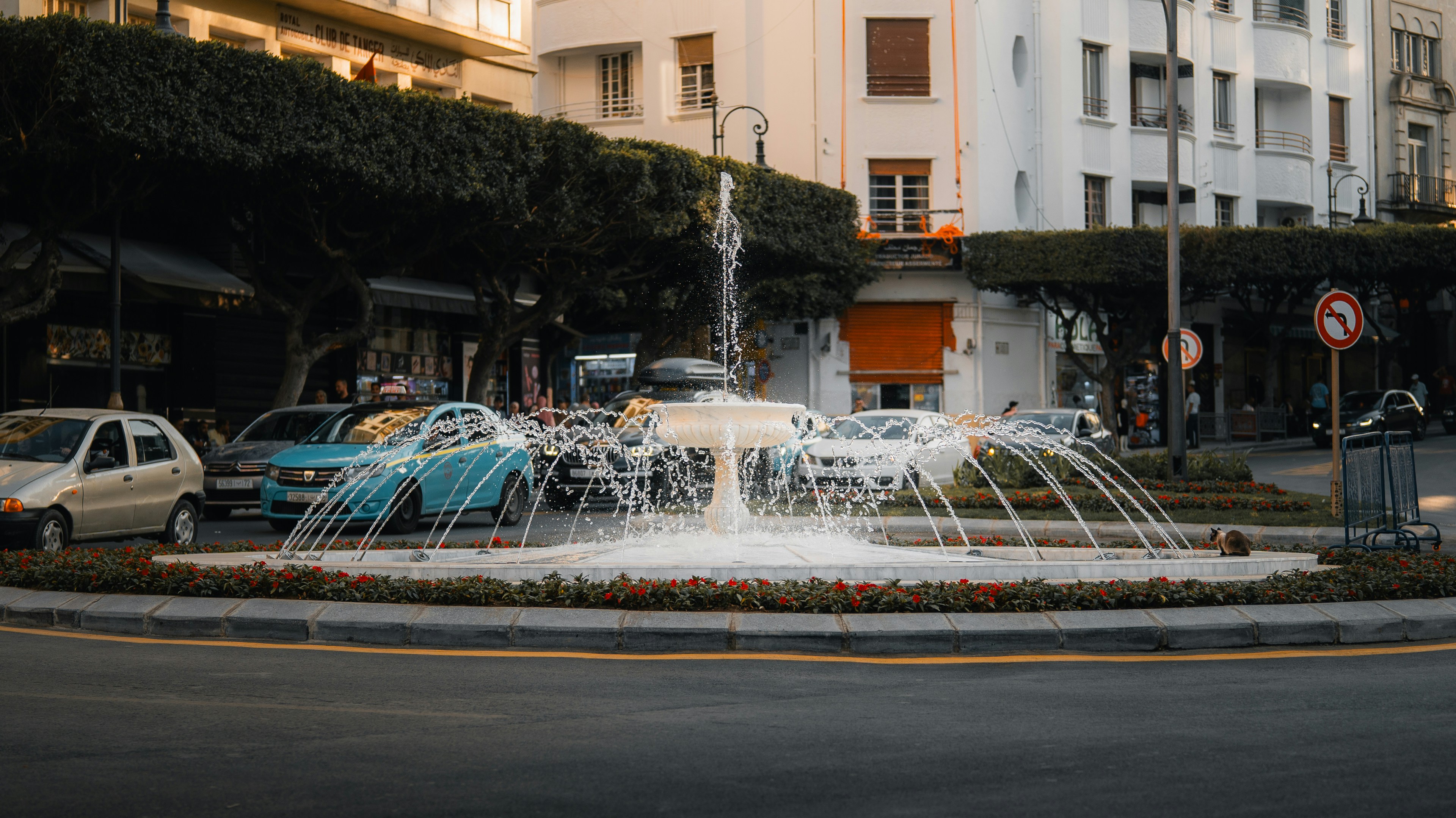 A fountain spouts water in a city circle. photo – Free Travel Image on ...