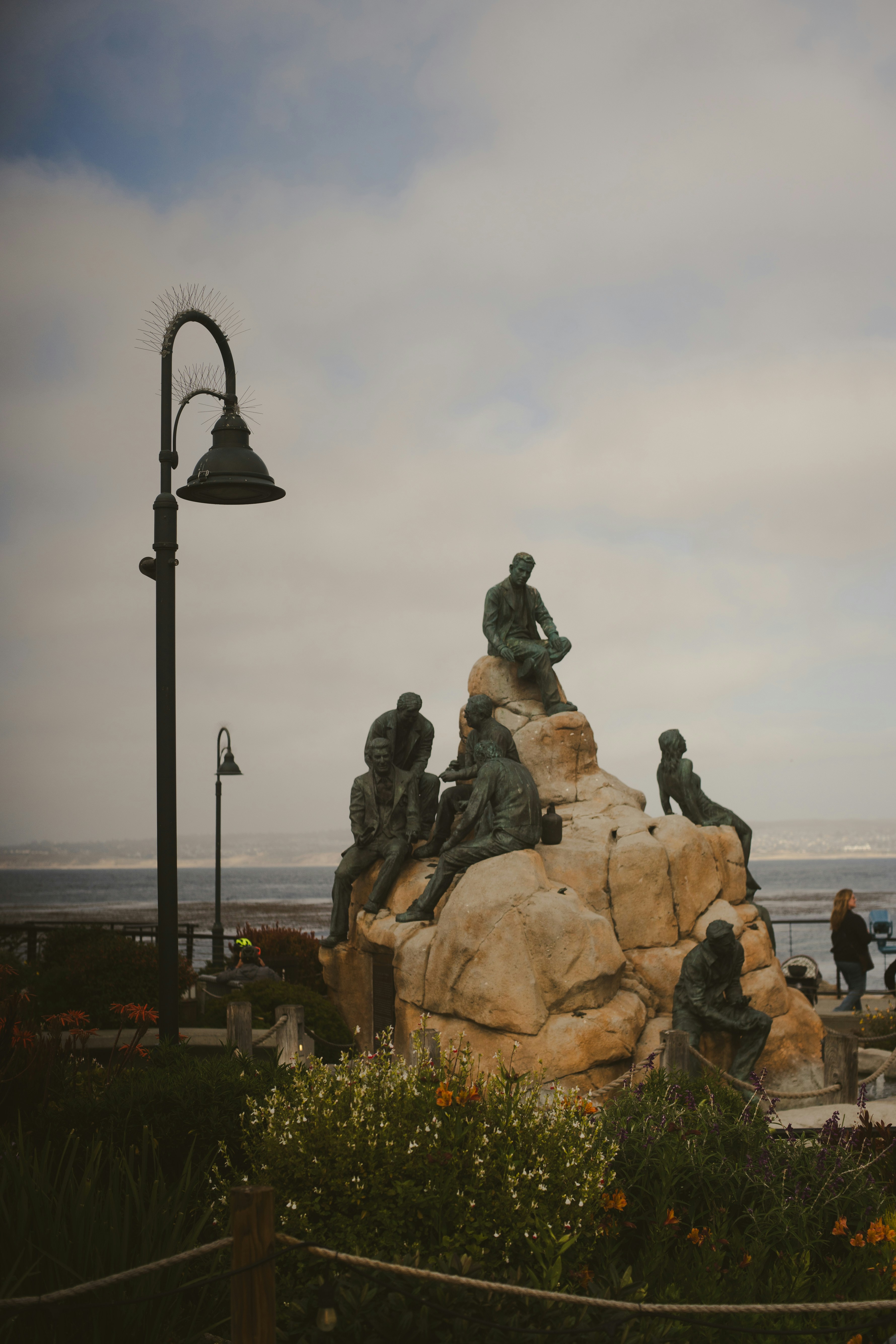 Bronze Figures Ascend the Seaside Rock: A Quiet Monument by the Ocean
