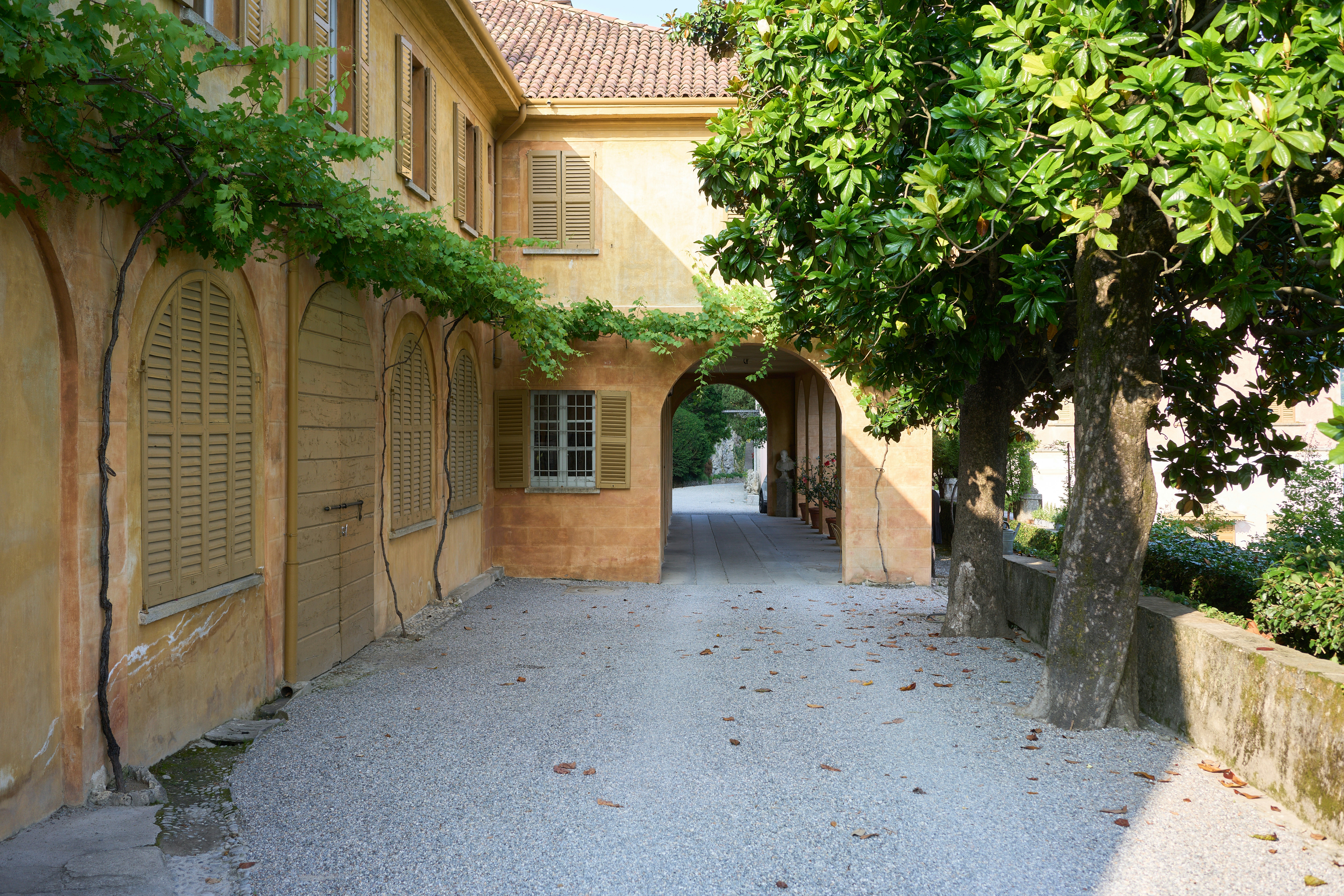 A walkway with an old building and trees.