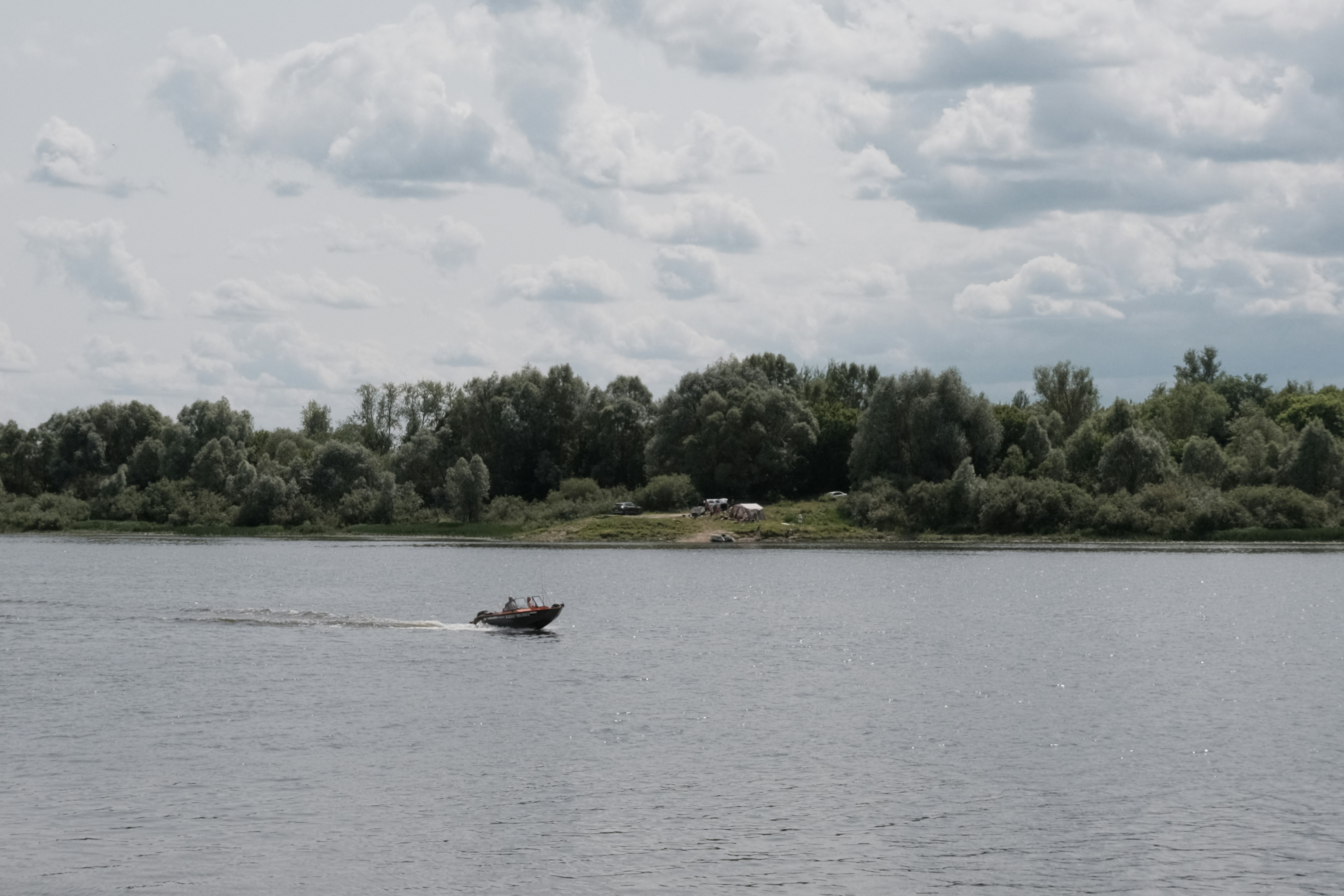 Whisper on the Wide River: A Lone Motorboat Traces a Silver Wake