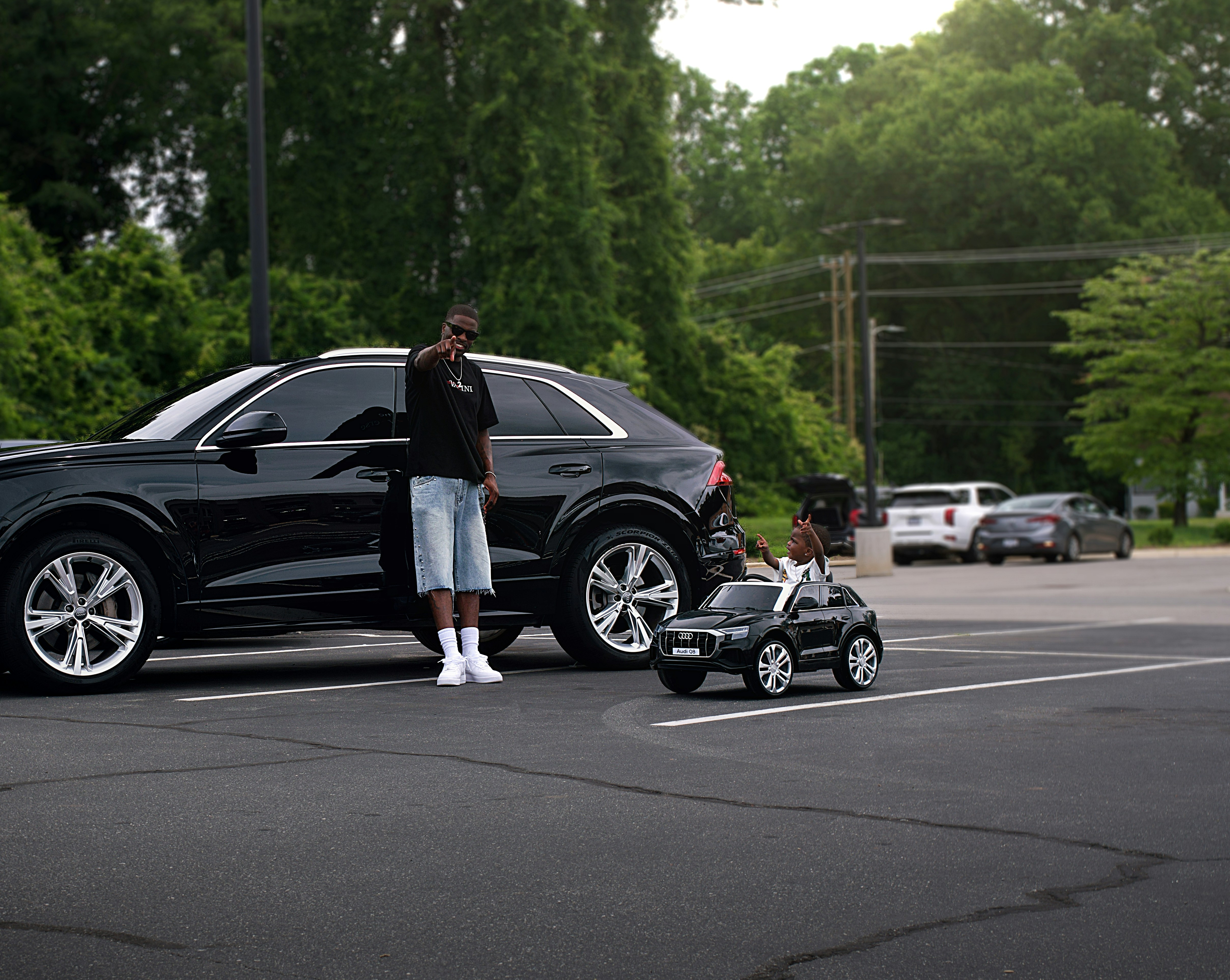 Parallel Play in the Parking Lot: A Man, a Sleek SUV, and a Toy Car
