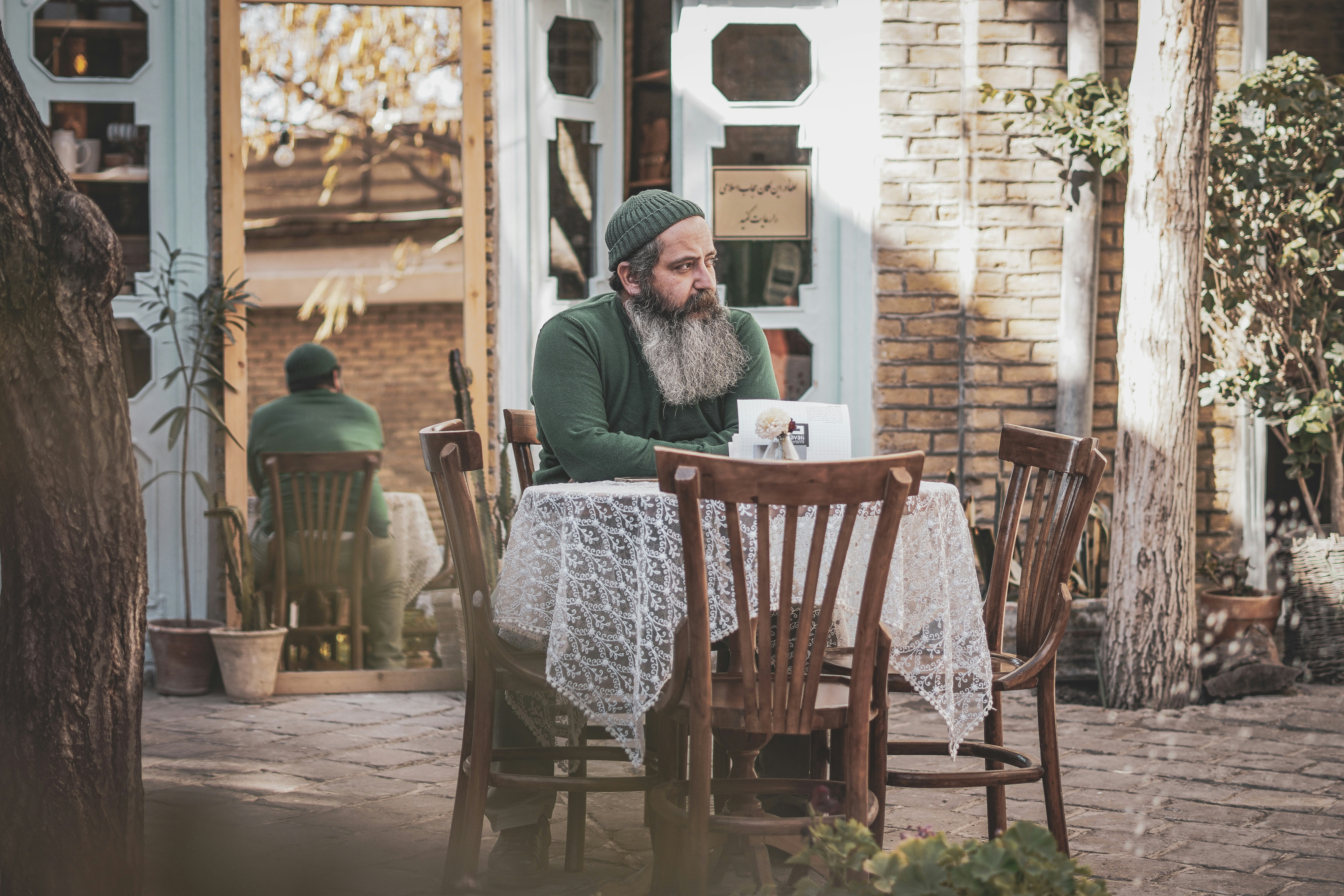 A portrait of time — an elder with a long white beard, seated in quiet dignity within the worn textures of a traditional Iranian home. Wood creaks, light fades, but presence endures. NO:02