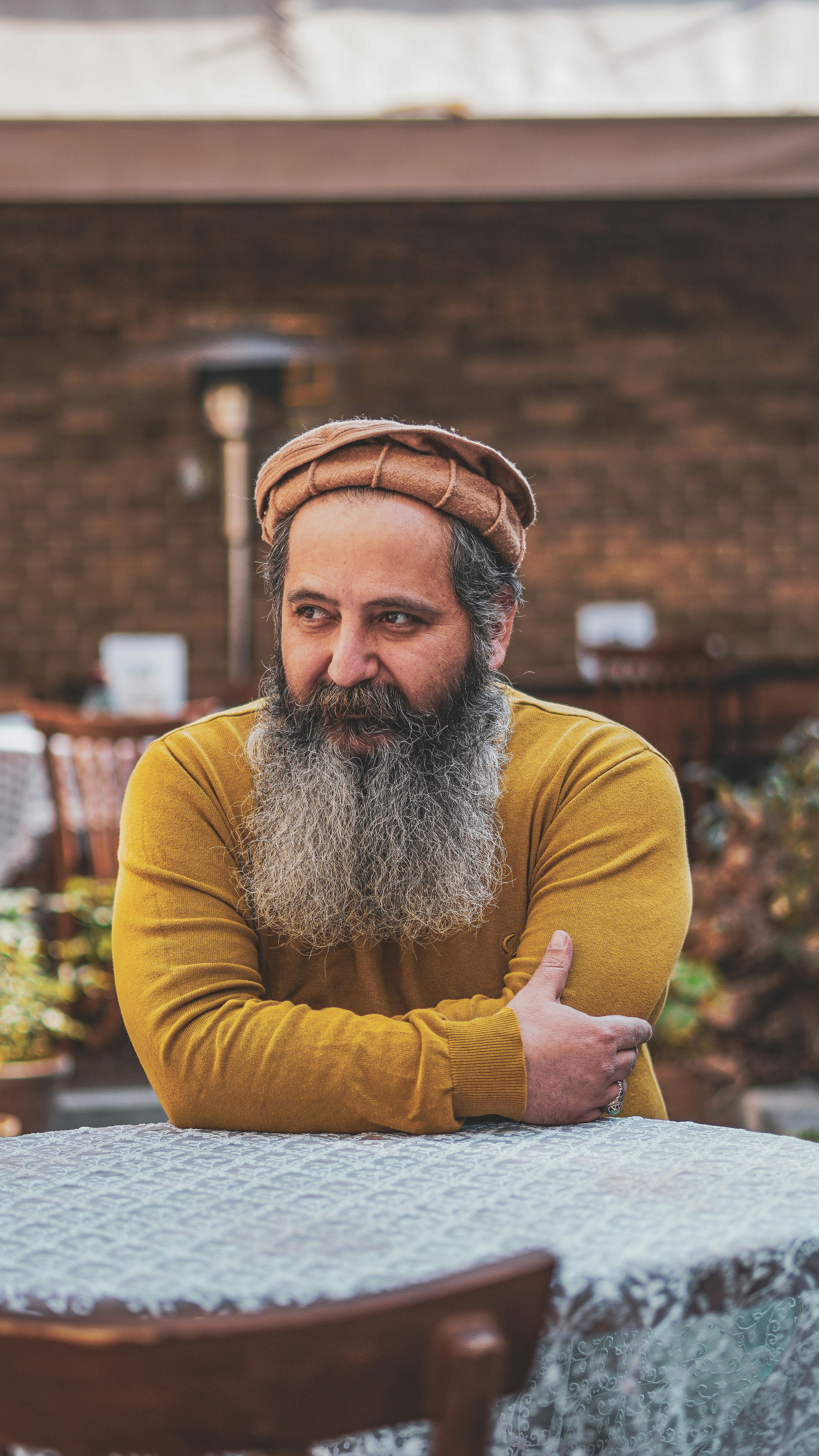 Sunlit Café Portrait: A Weathered Beard in a Mustard Knit
