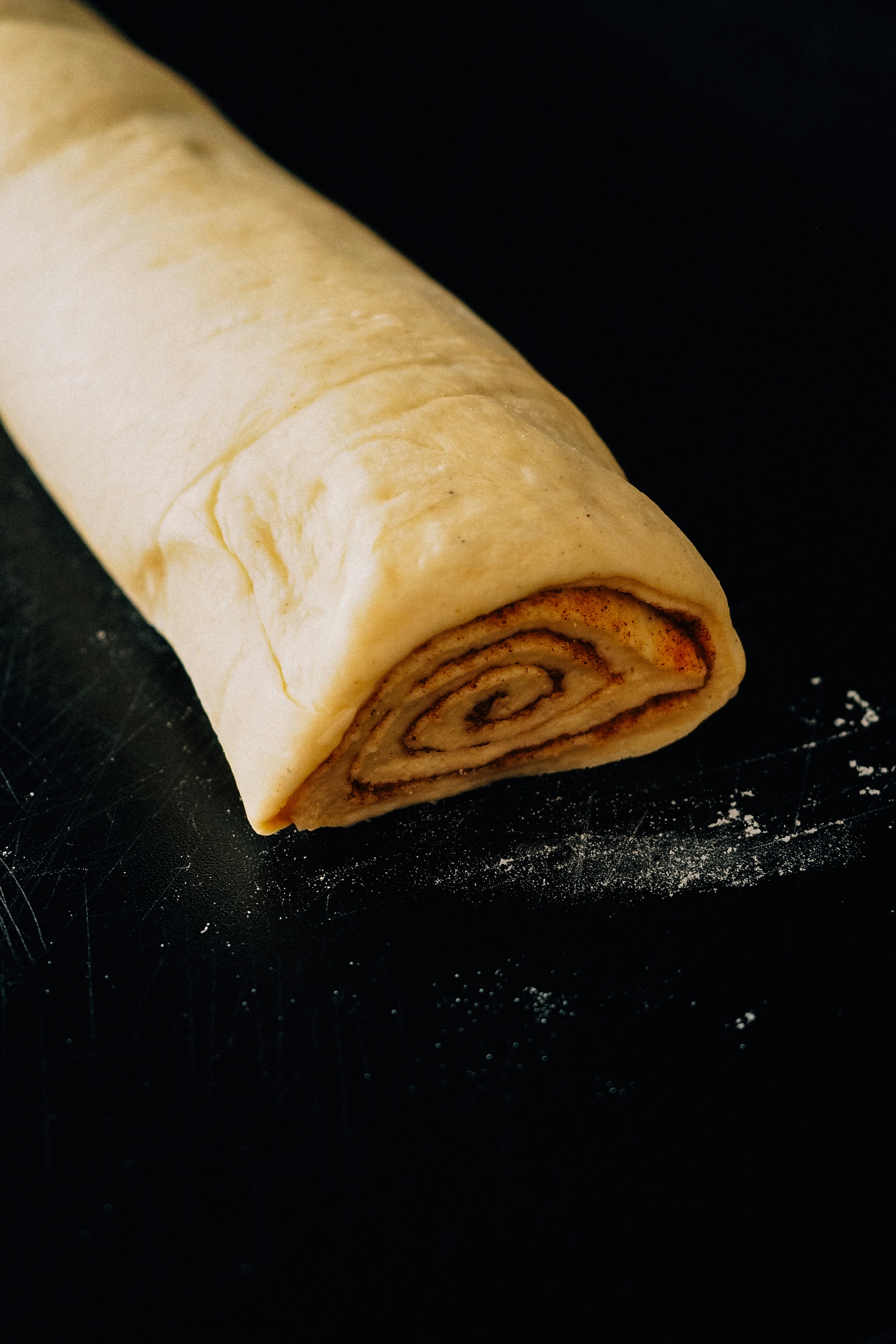 Cinnamon roll dough is ready for slicing.