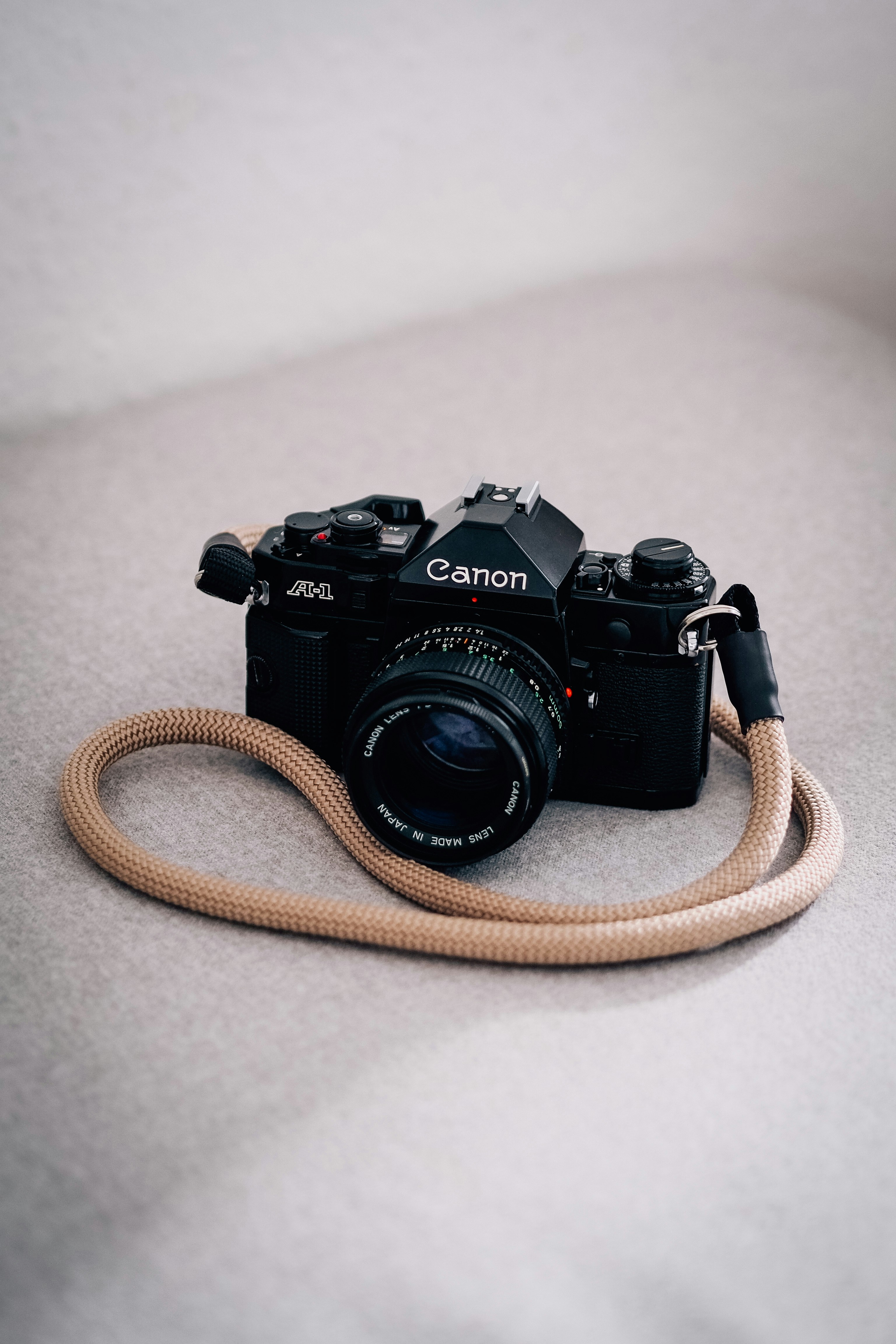 A black canon camera with a tan strap. photo – Free Photo Image on Unsplash