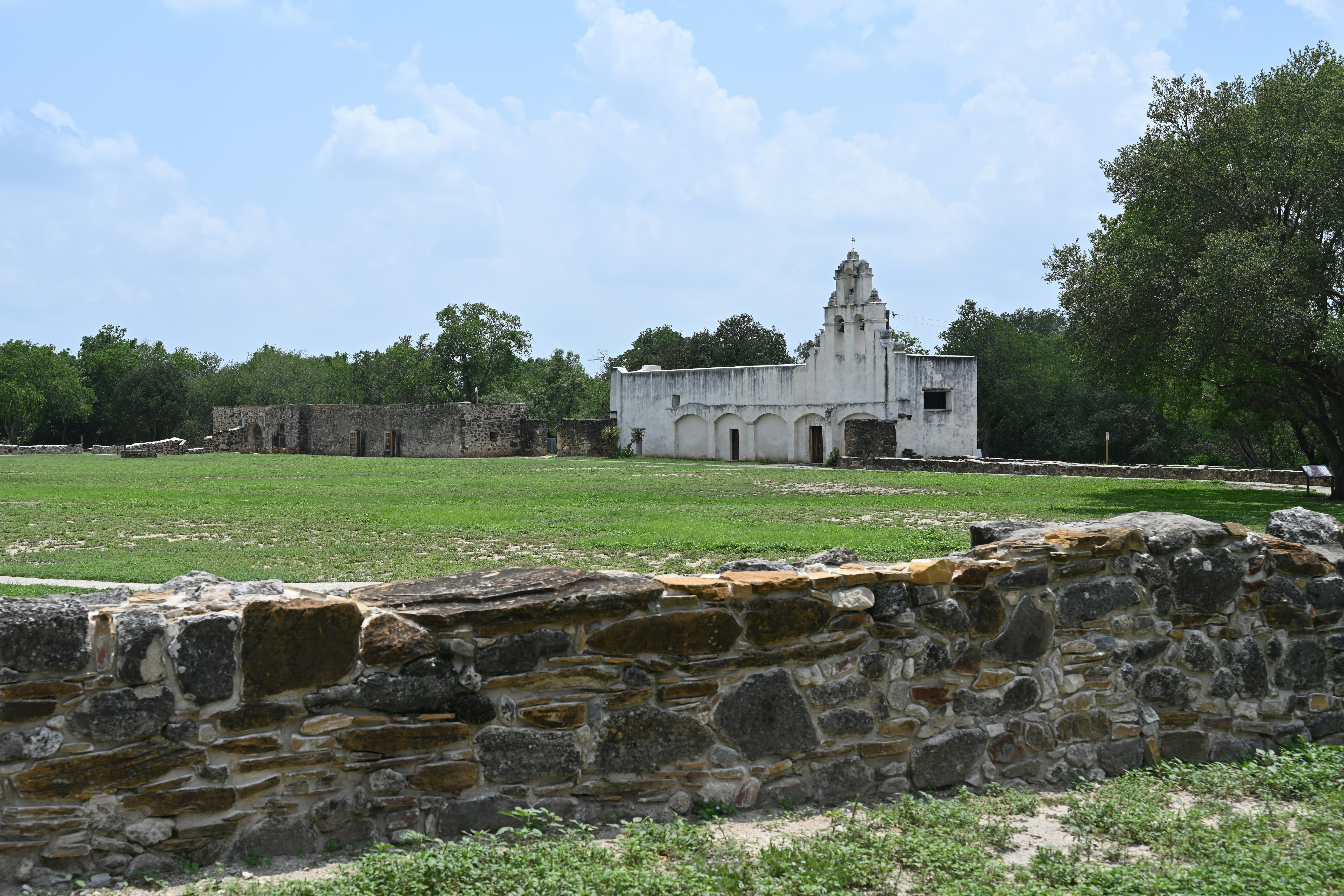 Mission San Juan | Old, white church stands in a grassy field.