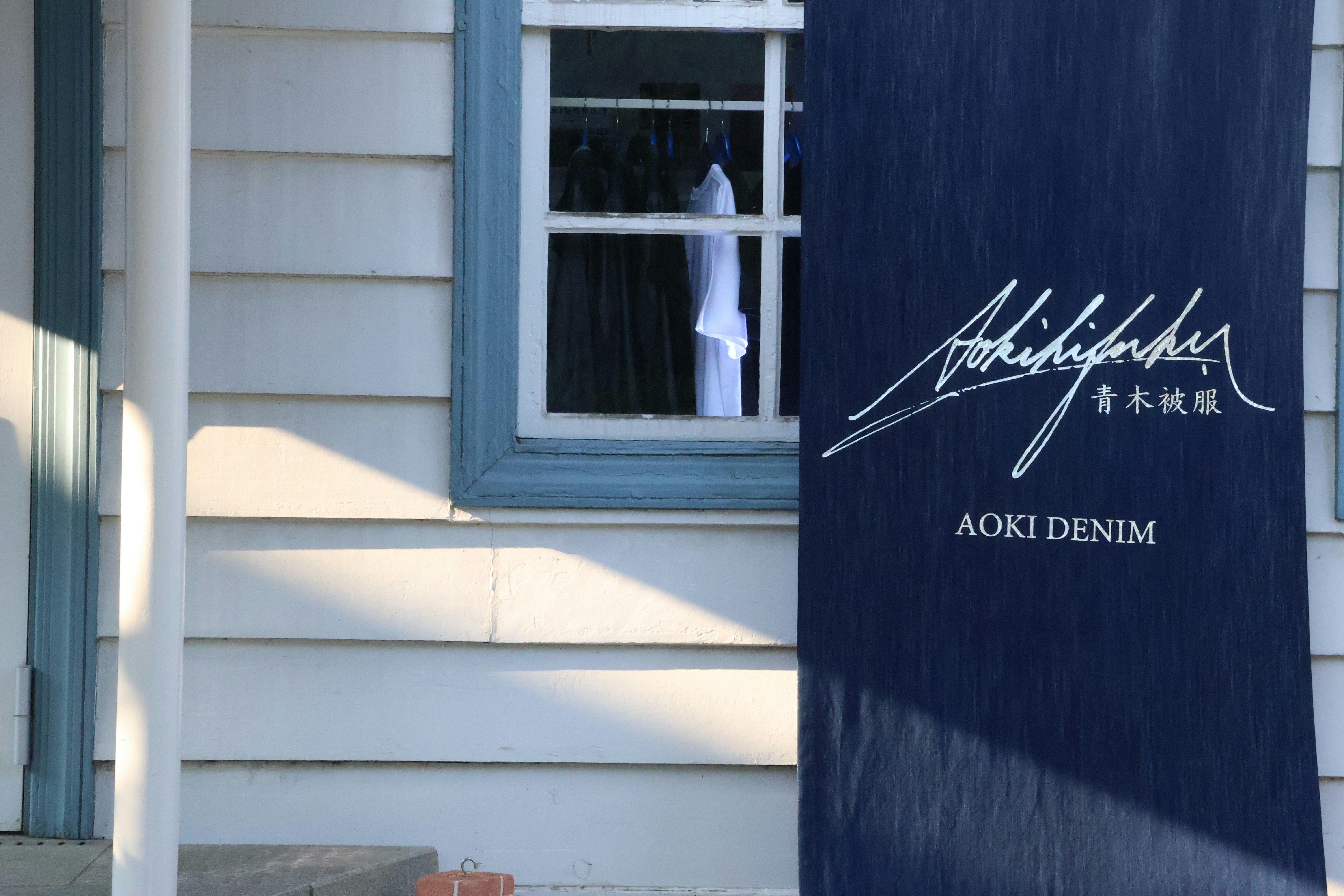 An aoki denim sign hangs outside a building. photo – Free Window Image on Unsplash