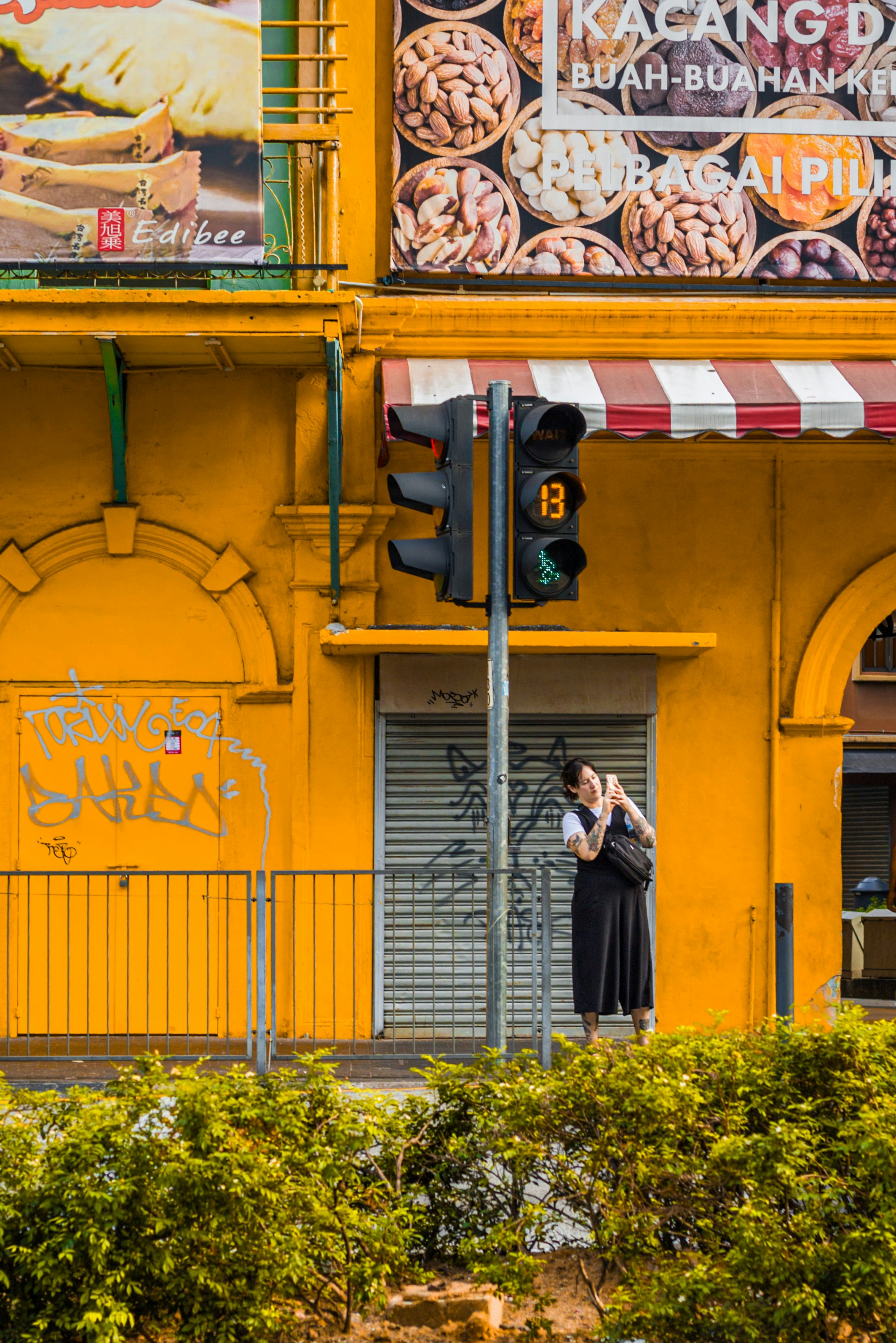 Woman looks at a street's traffic light. photo – Free People Image on ...