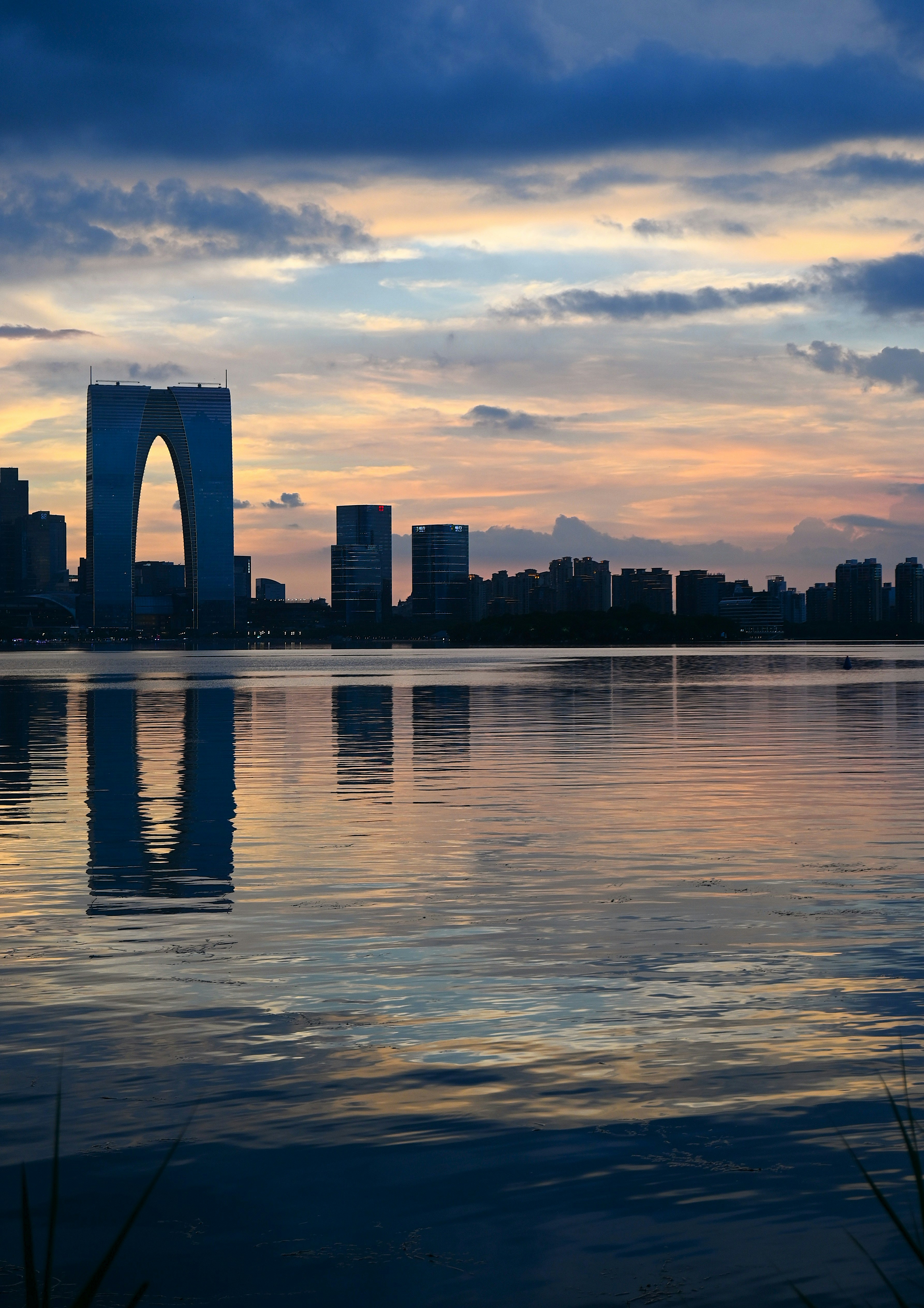 Sunset illuminates city buildings reflected in water. photo – Free ...