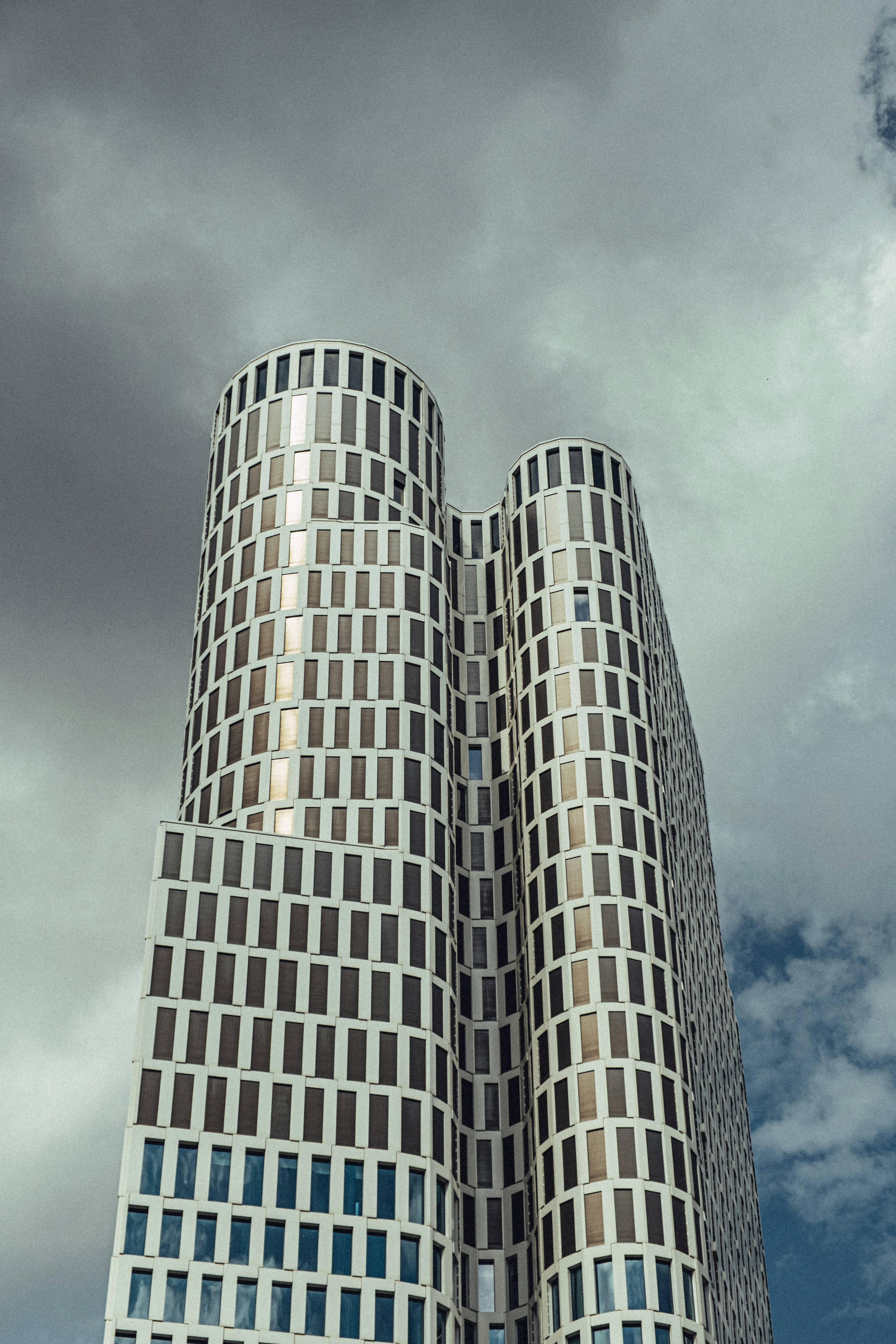 A modern skyscraper towers against a cloudy sky. photo – Free Building ...
