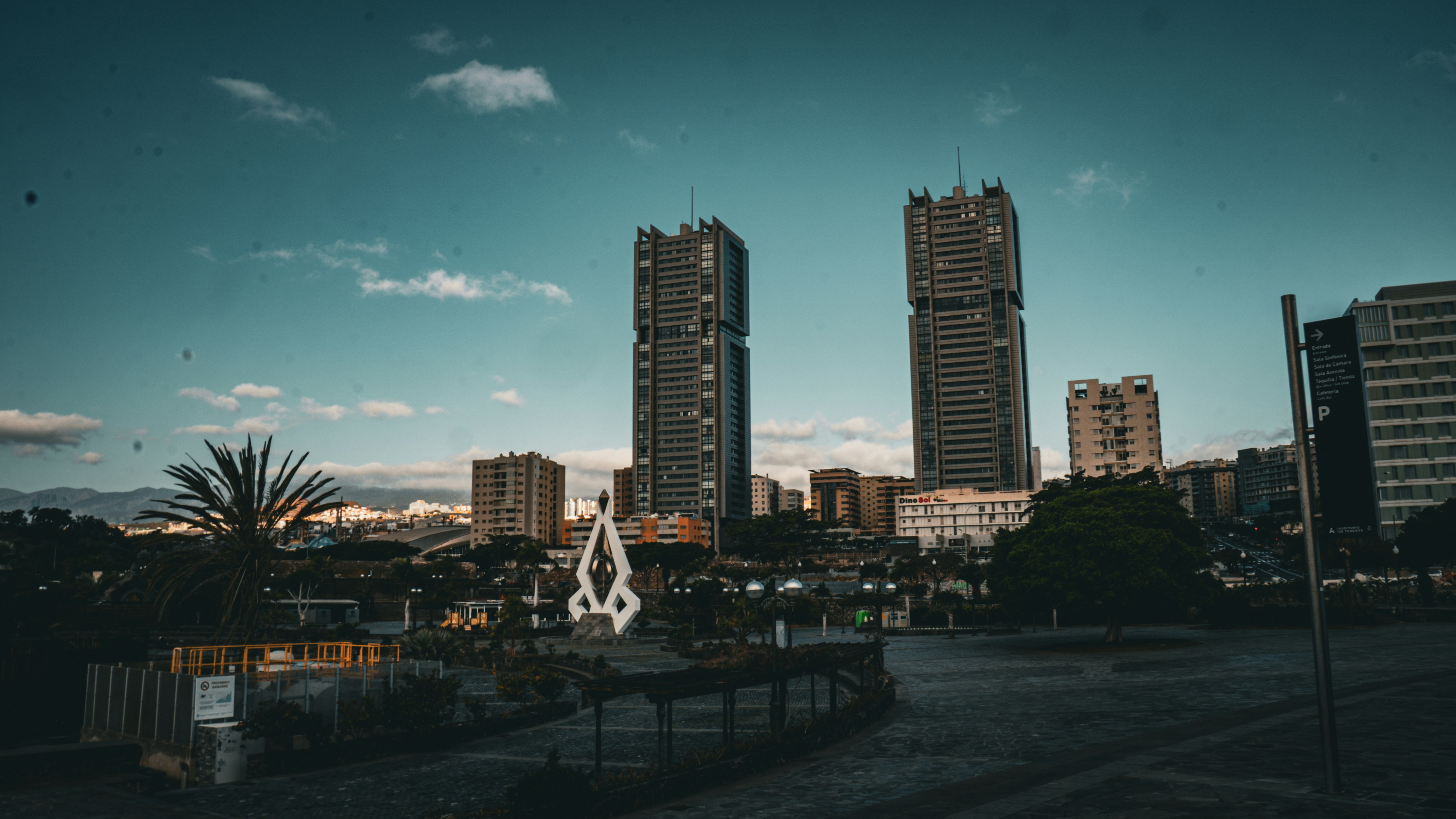 Skyscrapers stand tall against a blue and cloudy sky.
