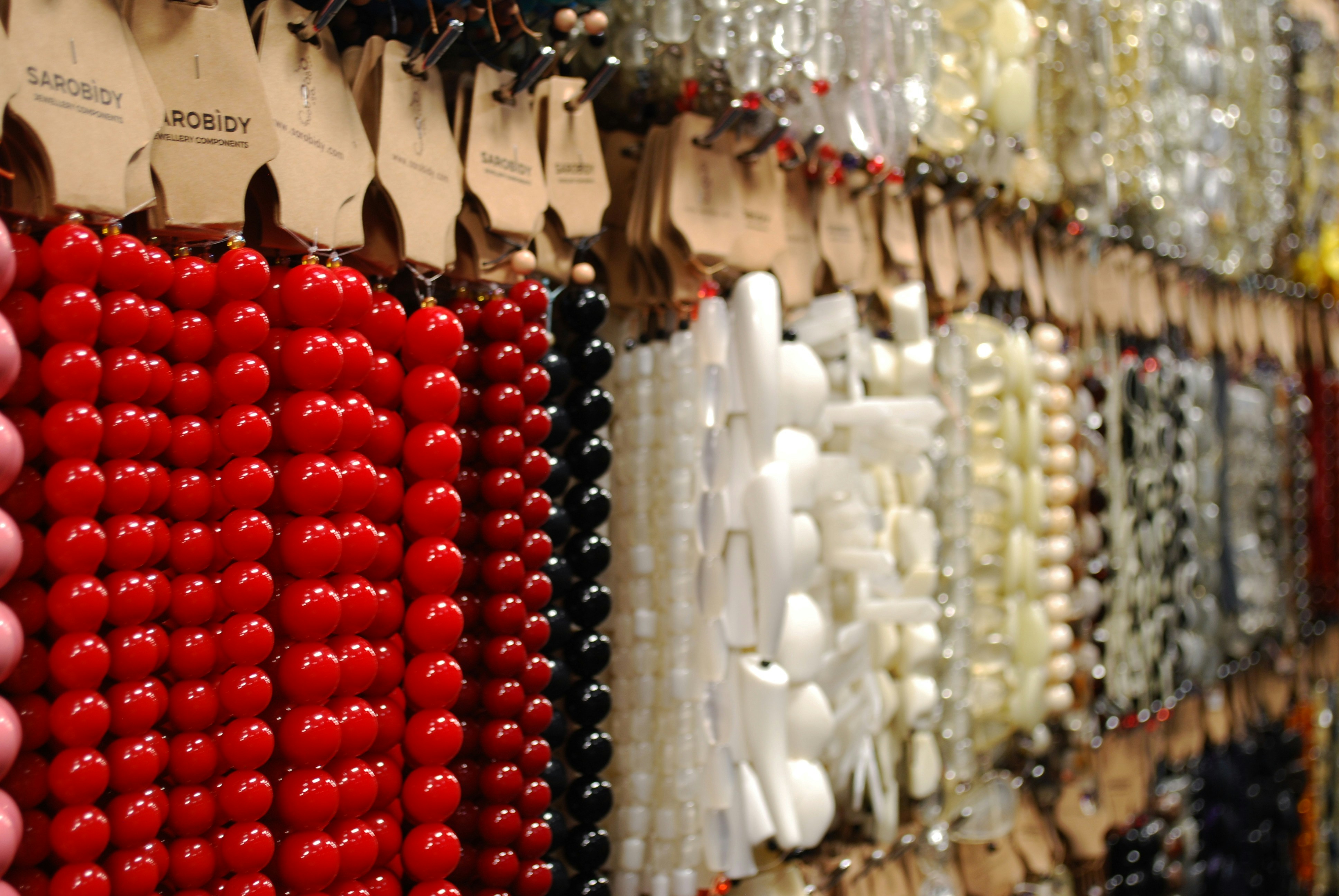 Strings of colorful beads hang for sale.