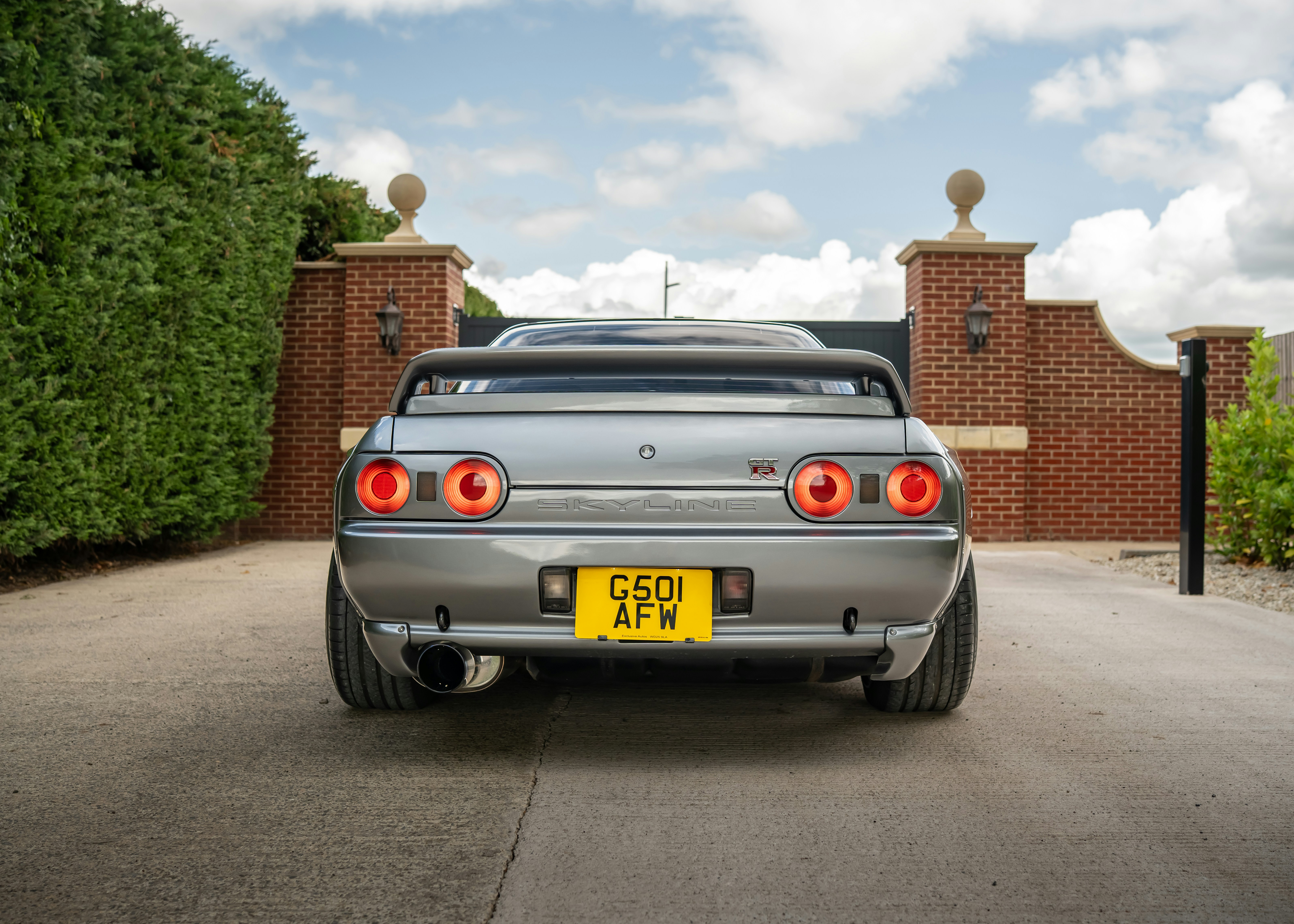 A nissan skyline r32 is parked at a gate. photo – Free Car Image on Unsplash