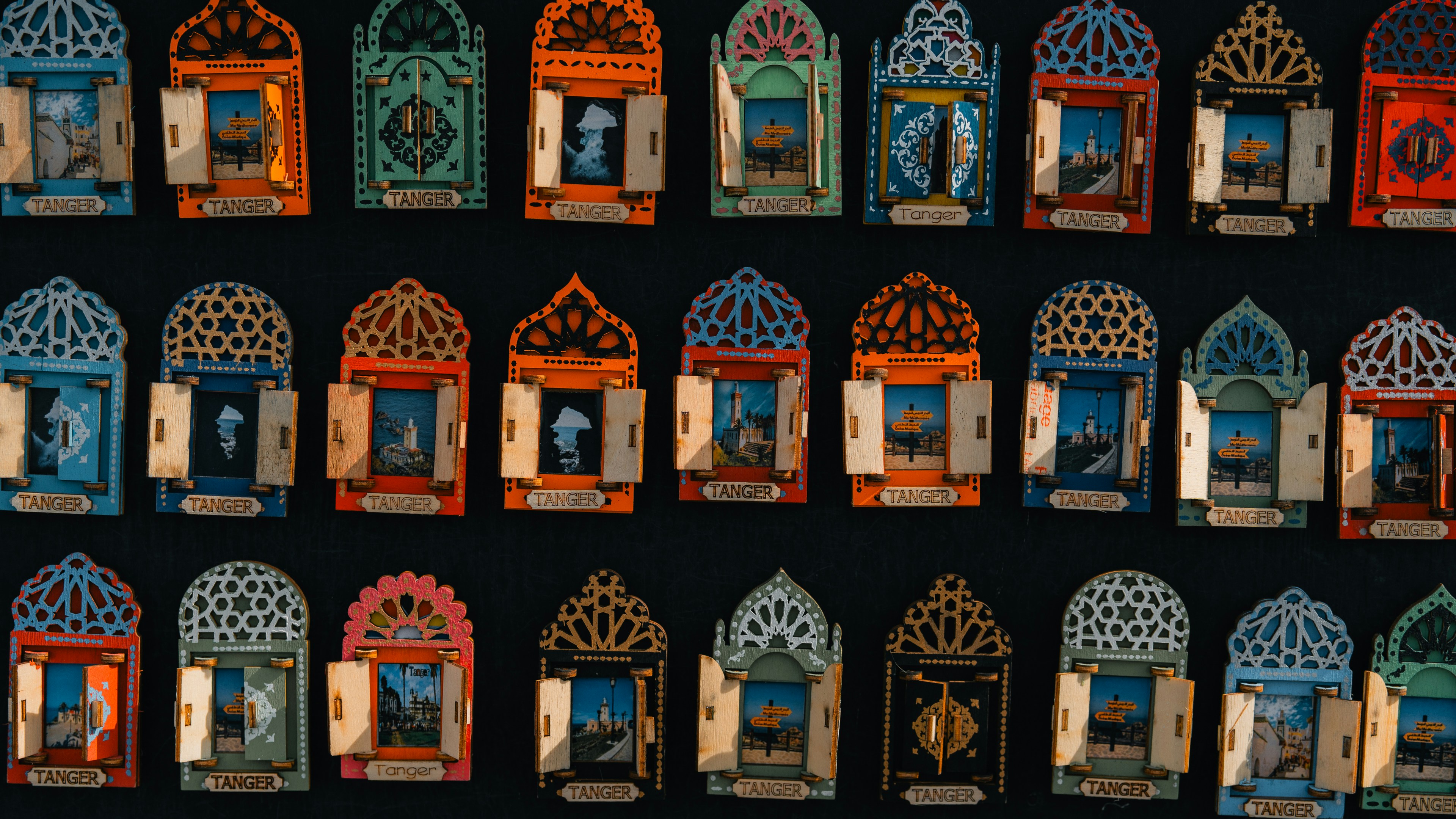 Colorful handcrafted wooden windows from Tangier, showcasing intricate designs and scenic views. Each window tells a unique story.