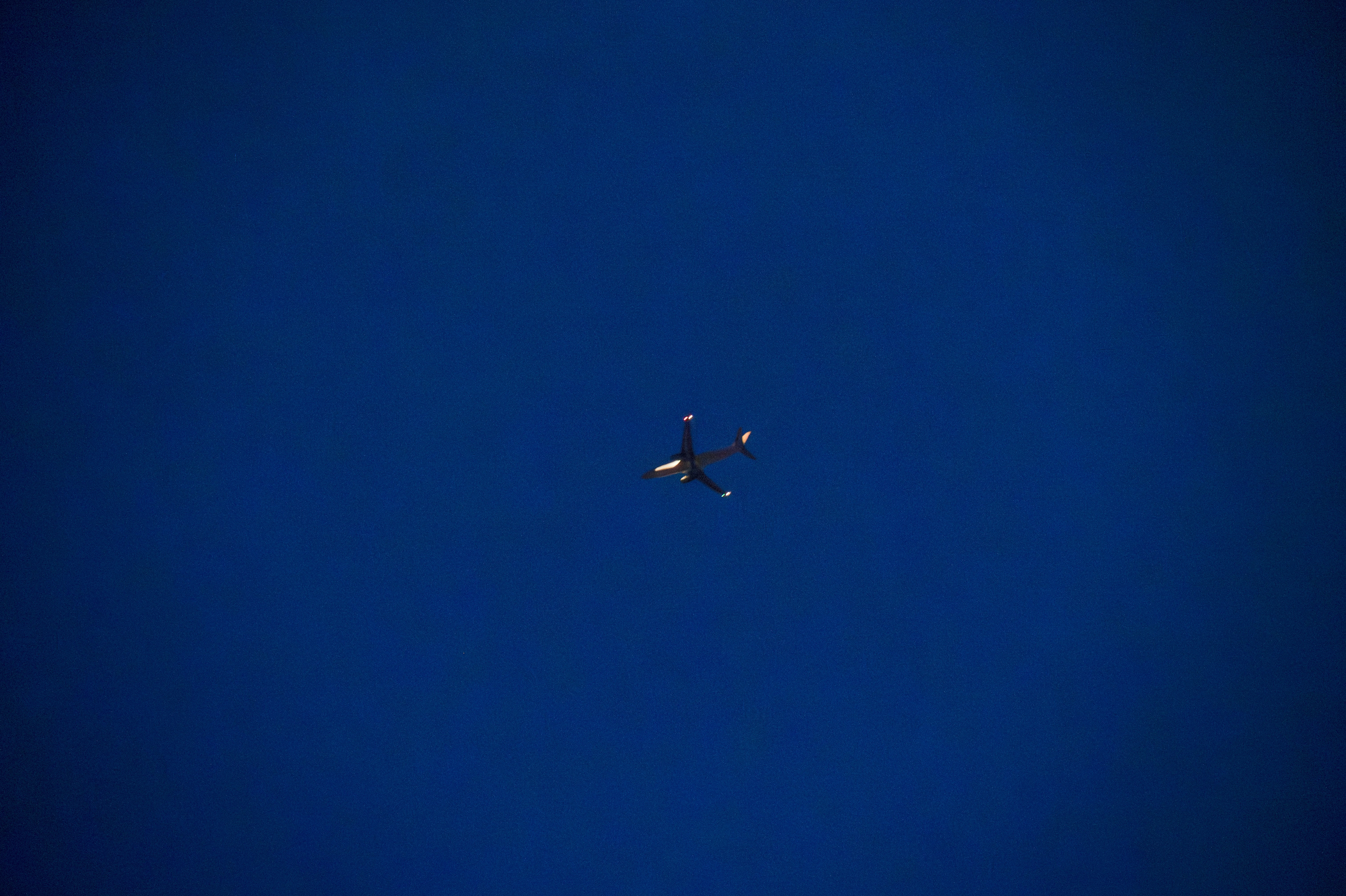 Drone hovering against a clear blue sky, capturing the vastness of the landscape below.