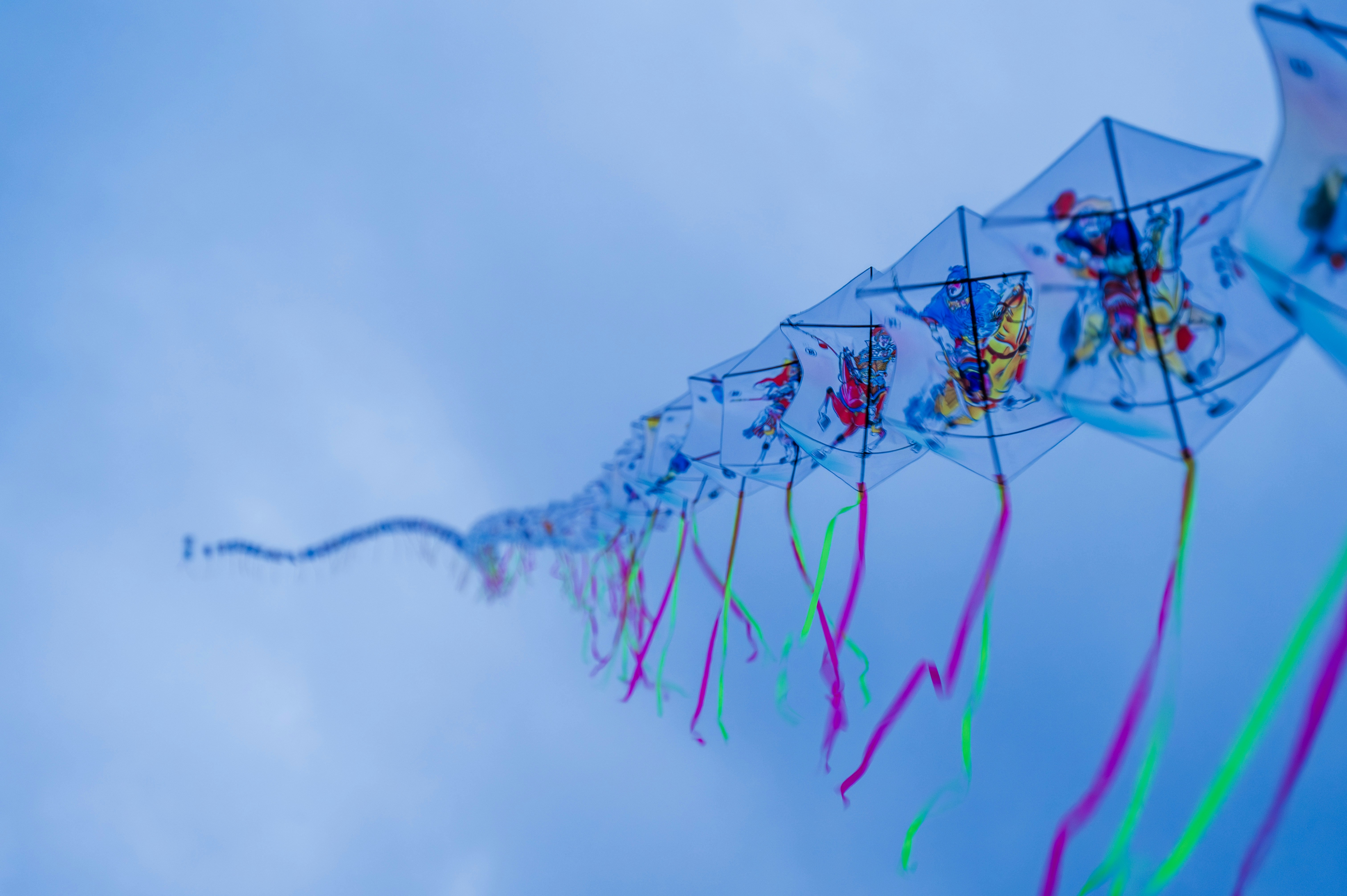 Kite Streamers in Flight: Colorful Tails Against a Soft Blue Sky