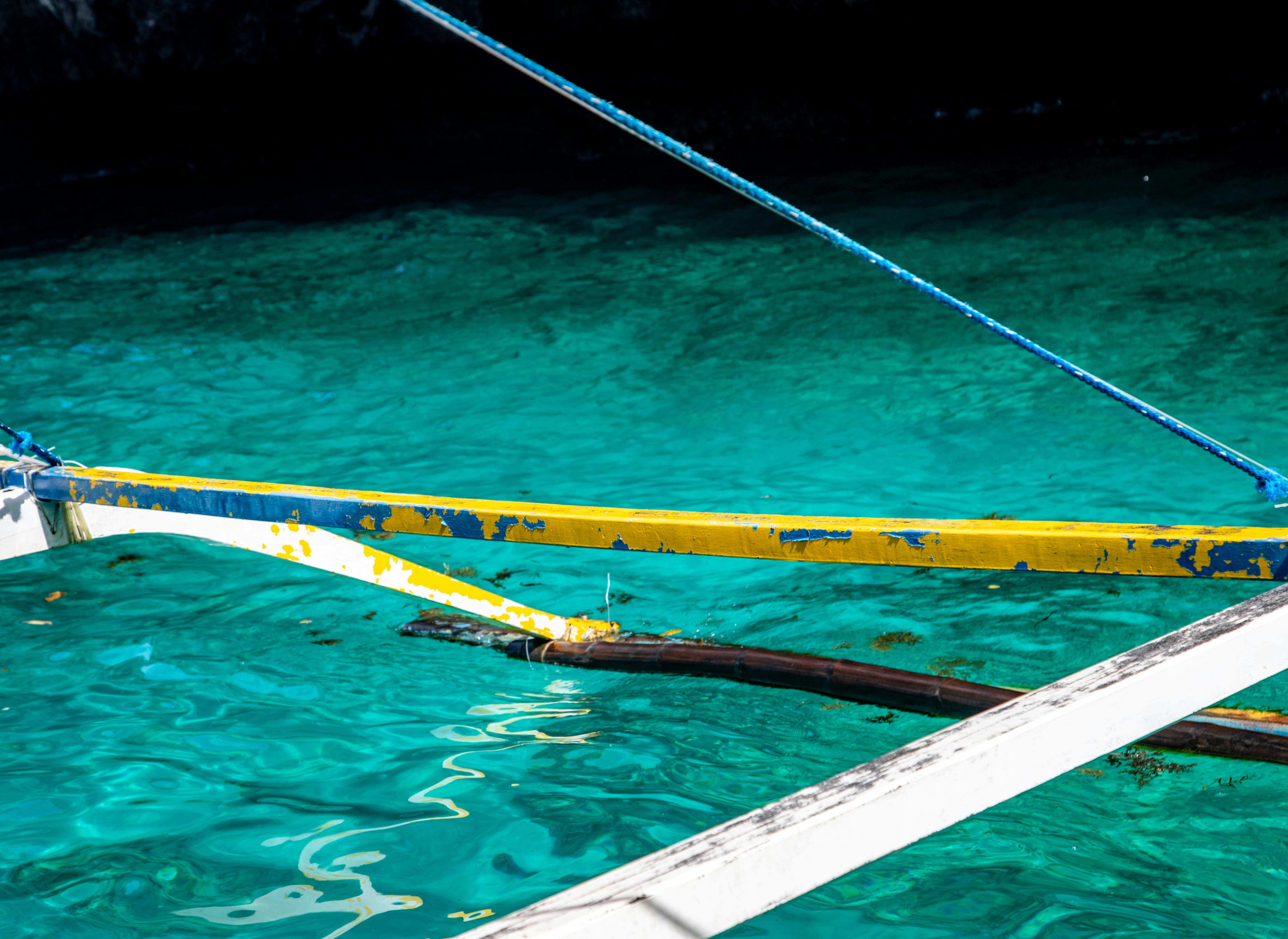 Crossed Lines over Turquoise Sea: A Weathered Outrigger Frame