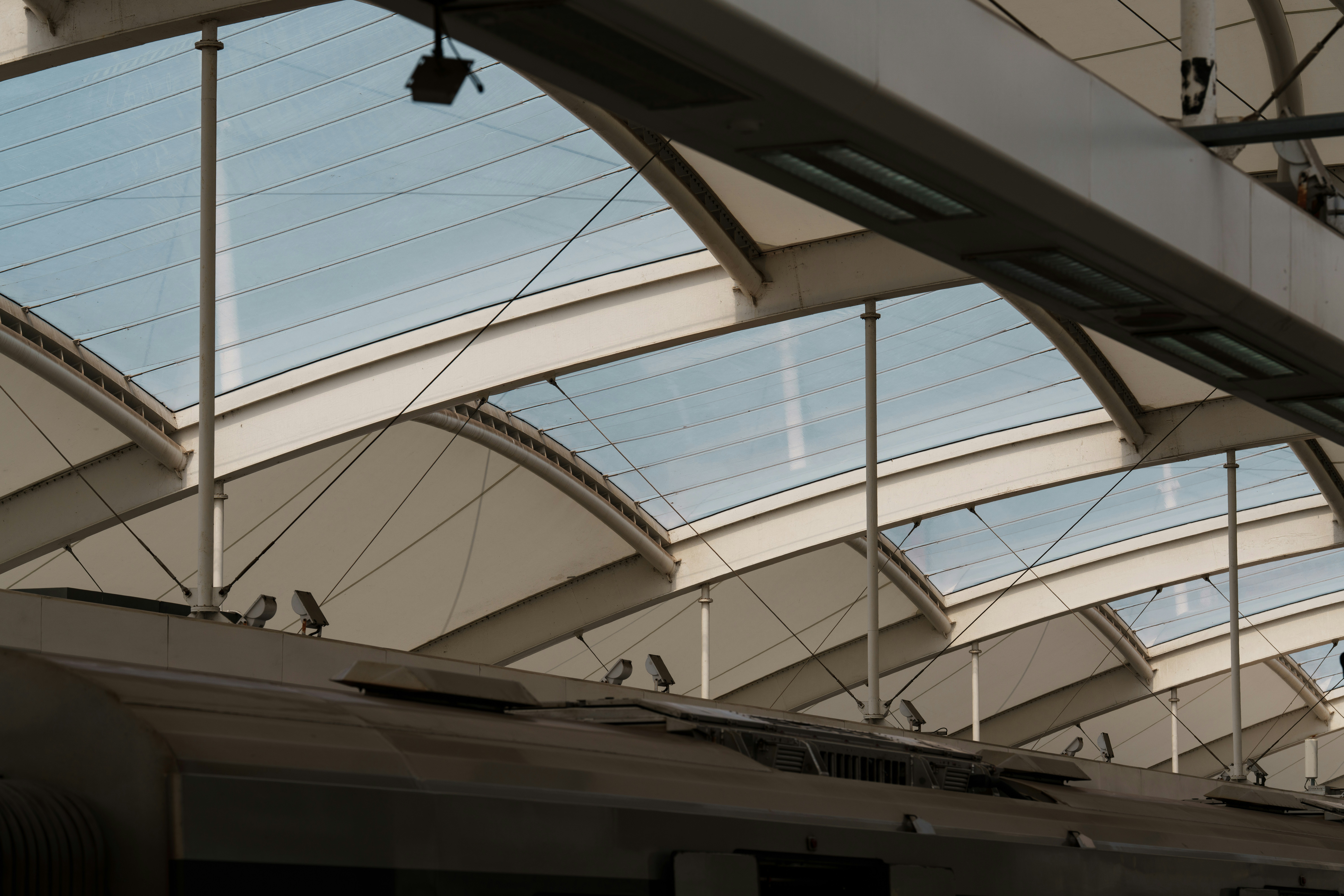 Ribbed Skyline: Sunlit Arches Over a Quiet Station