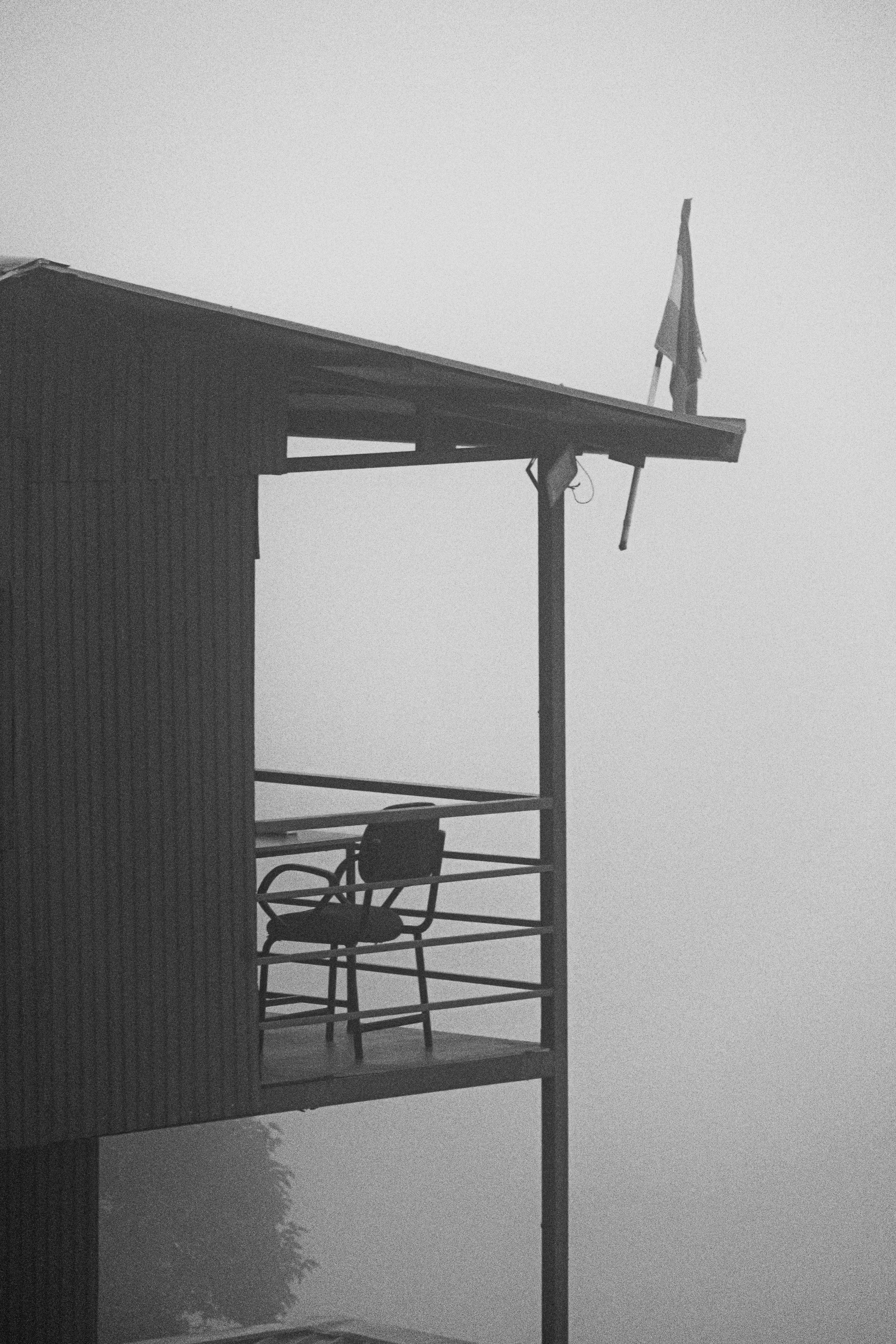 Fogbound Balcony: A Solitary Chair Watches Over Silence