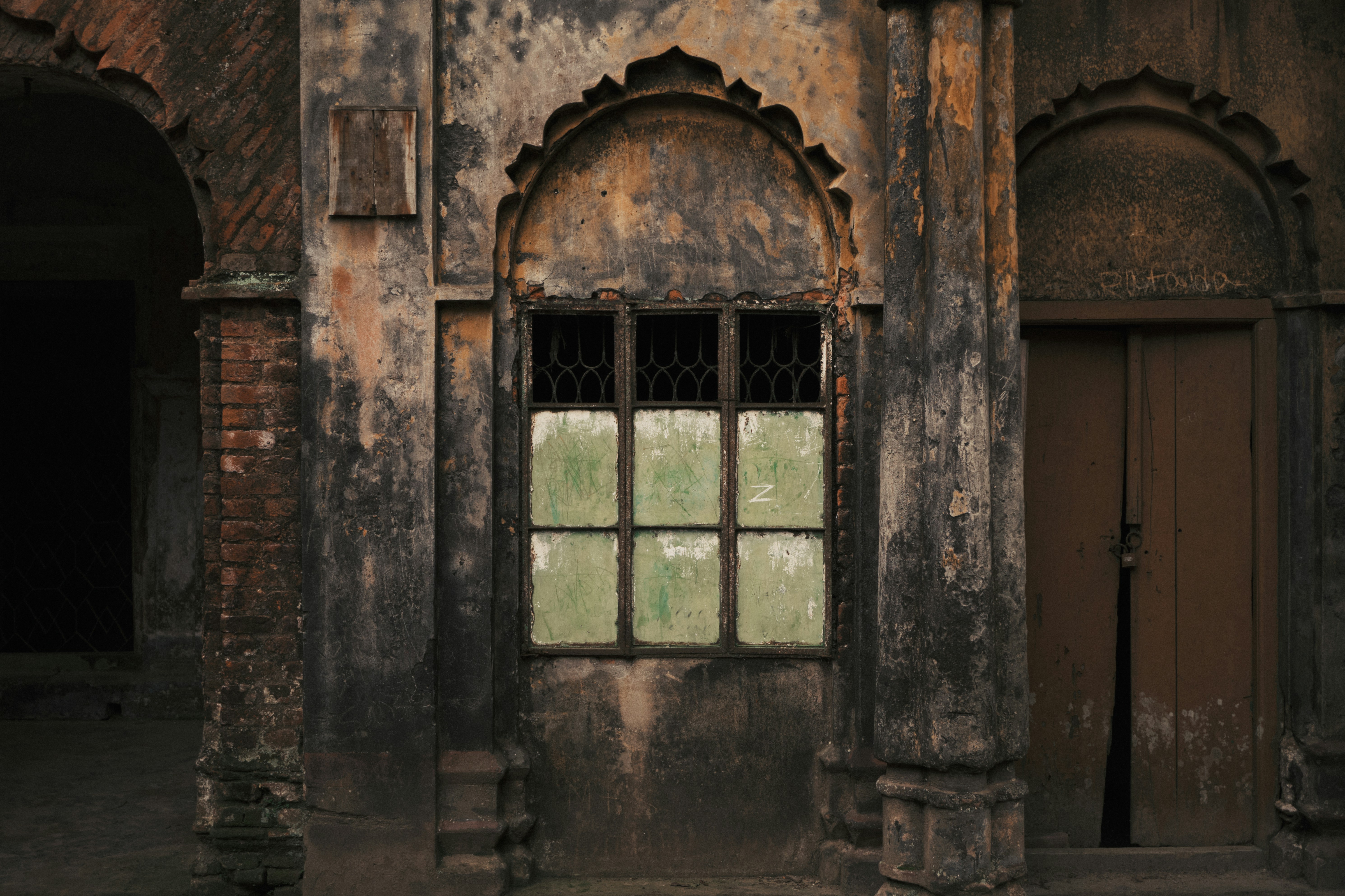 Old building facade with a window and door.
