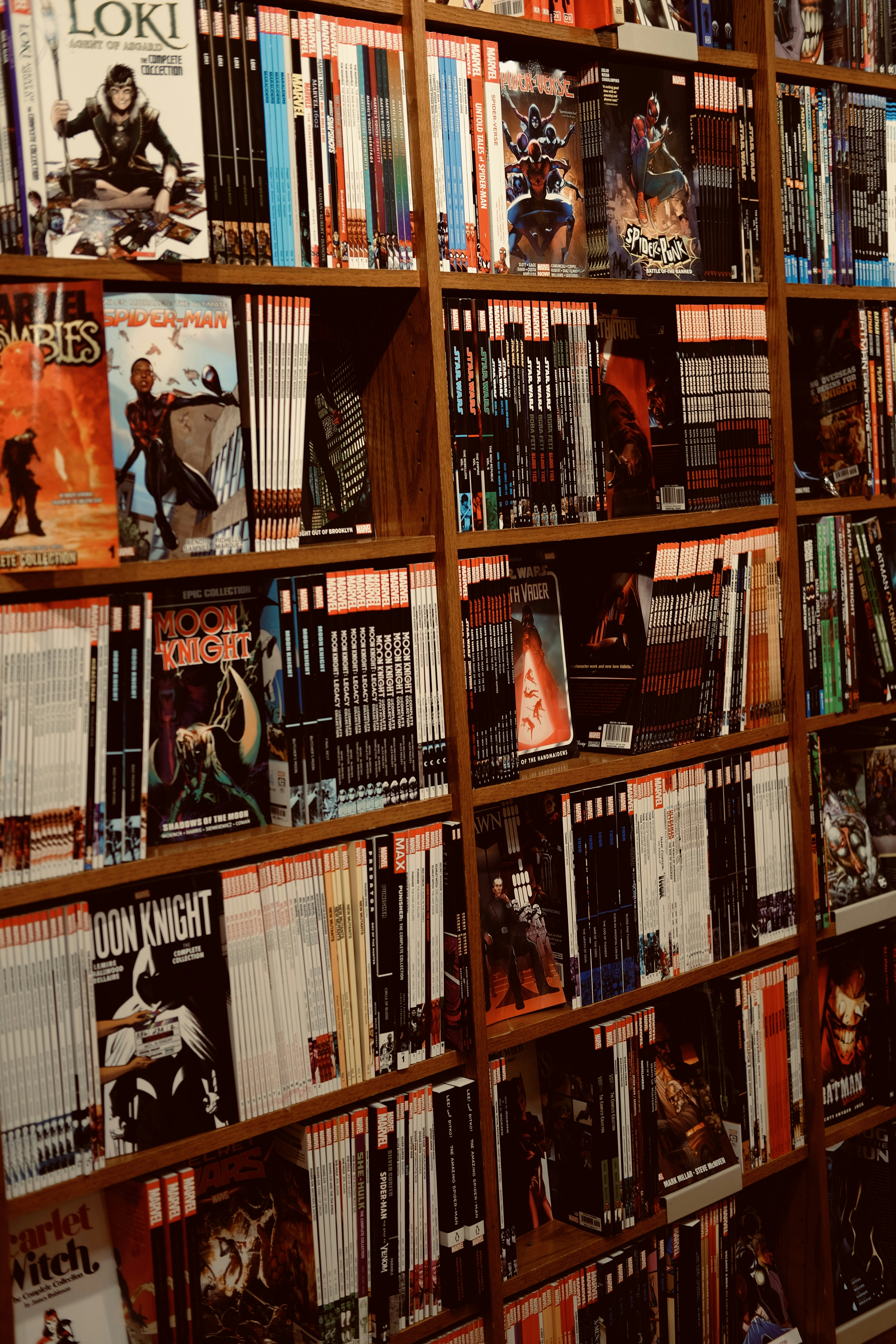 Zwischen Spider-Man, Moon Knight und Star Wars stapeln sich die Panels, Geschichten und Universen. Dieses Regal ist nicht nur voll – es ist ein Tor zu Dutzenden von Realitäten. Für Comic-Liebhaber:innen, Sammler:innen und alle, die mit Popkultur aufgewachsen sind, ist das hier kein Geschäft – es ist Heimat. | Shelves are filled with various comic books.