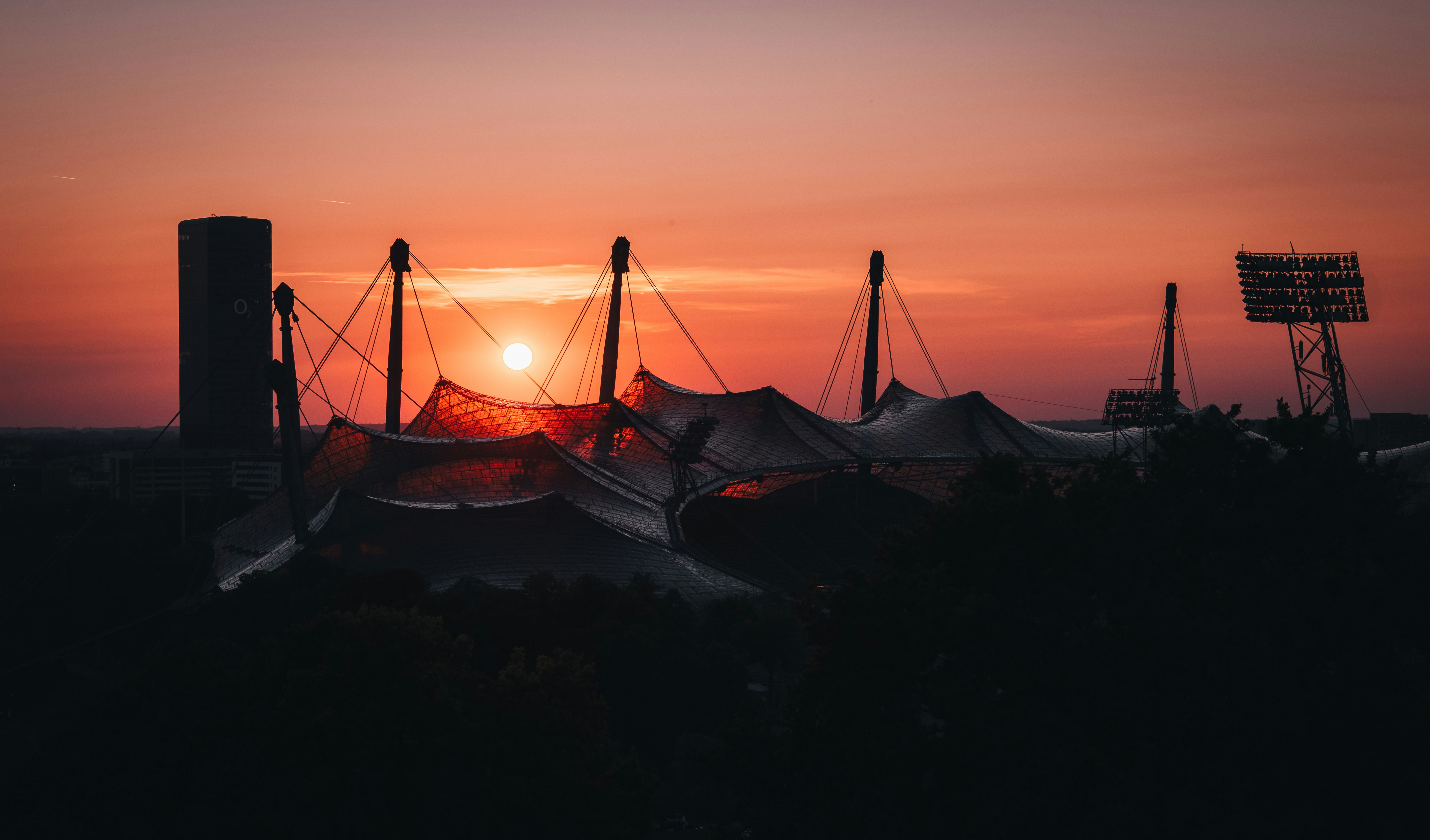 Sunset silhouettes a structure against a fiery sky.