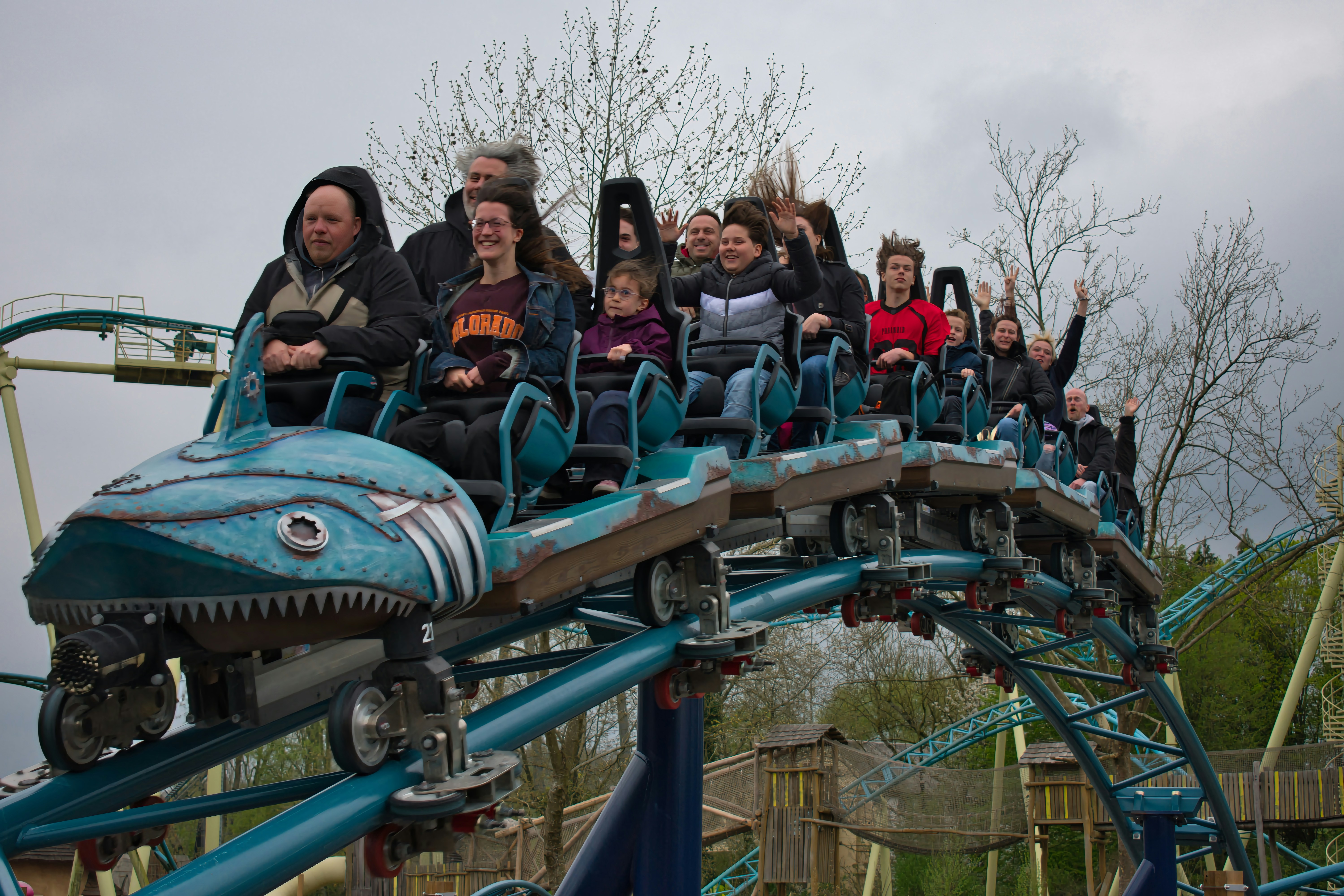Mecalodon — the mechanical shark unleashed. Three LSM boosts, 14 airtime moments, and a family-friendly rush across water — this Gerstlauer beast glides through Dock World with primal precision. Even the water’s edge can’t slow its hunt. Type: Family Launch Coaster (Gerstlauer Airtime Coaster) Opened: April 5 2025 Height: 15 m Length: 925 m Top Speed: 65 km/h Inversions: 0 Airtime Moments: 14 Launches: 3 LSM sections Duration: ~2:00 min Location: Dock World, Walibi Belgium | People enjoy a roller coaster ride.