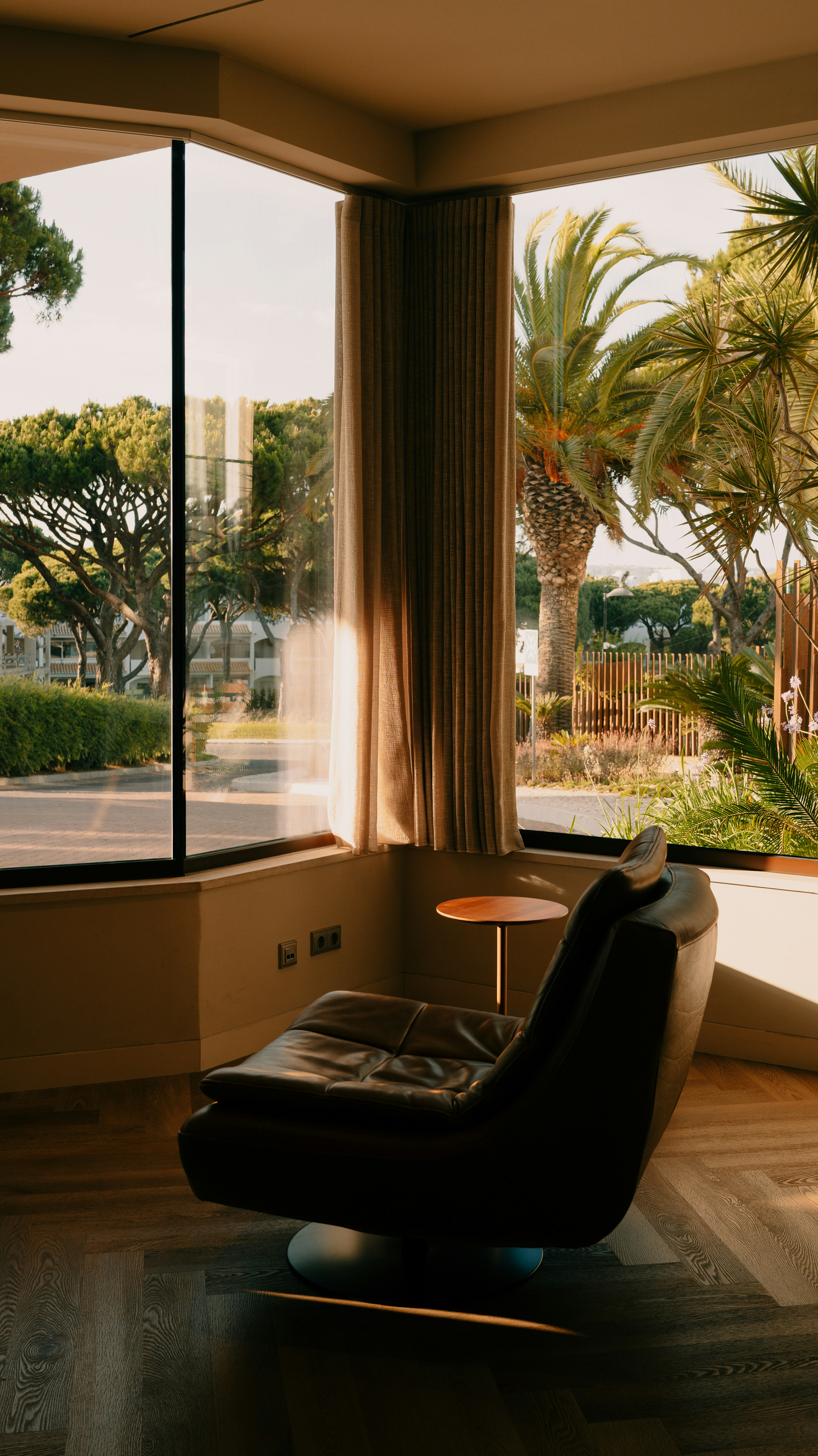 A cozy chair faces a sunny outdoor view.